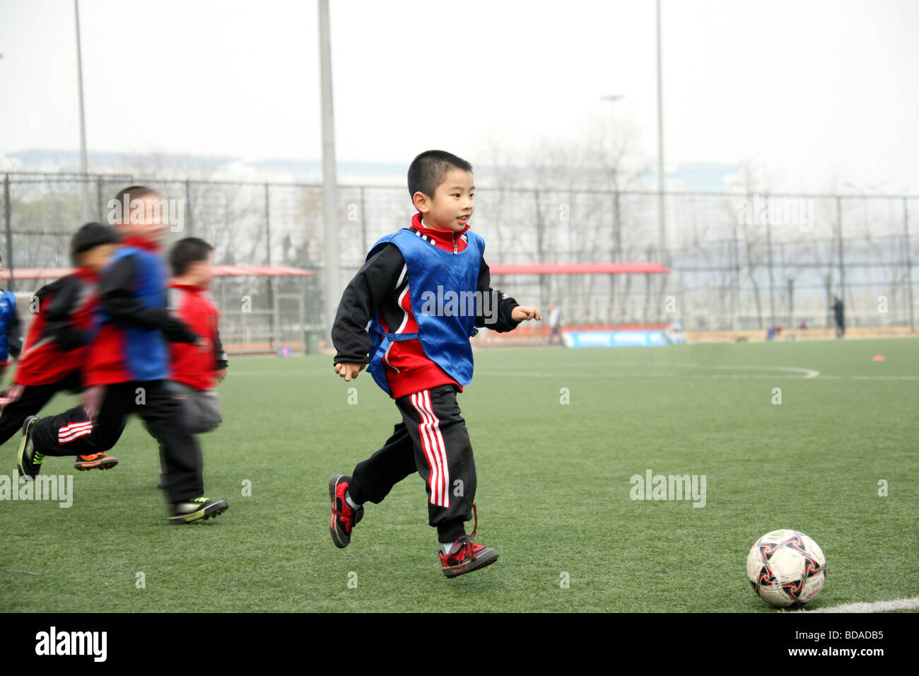 Chinese boy playing soccer on the field Stock Photo - Alamy