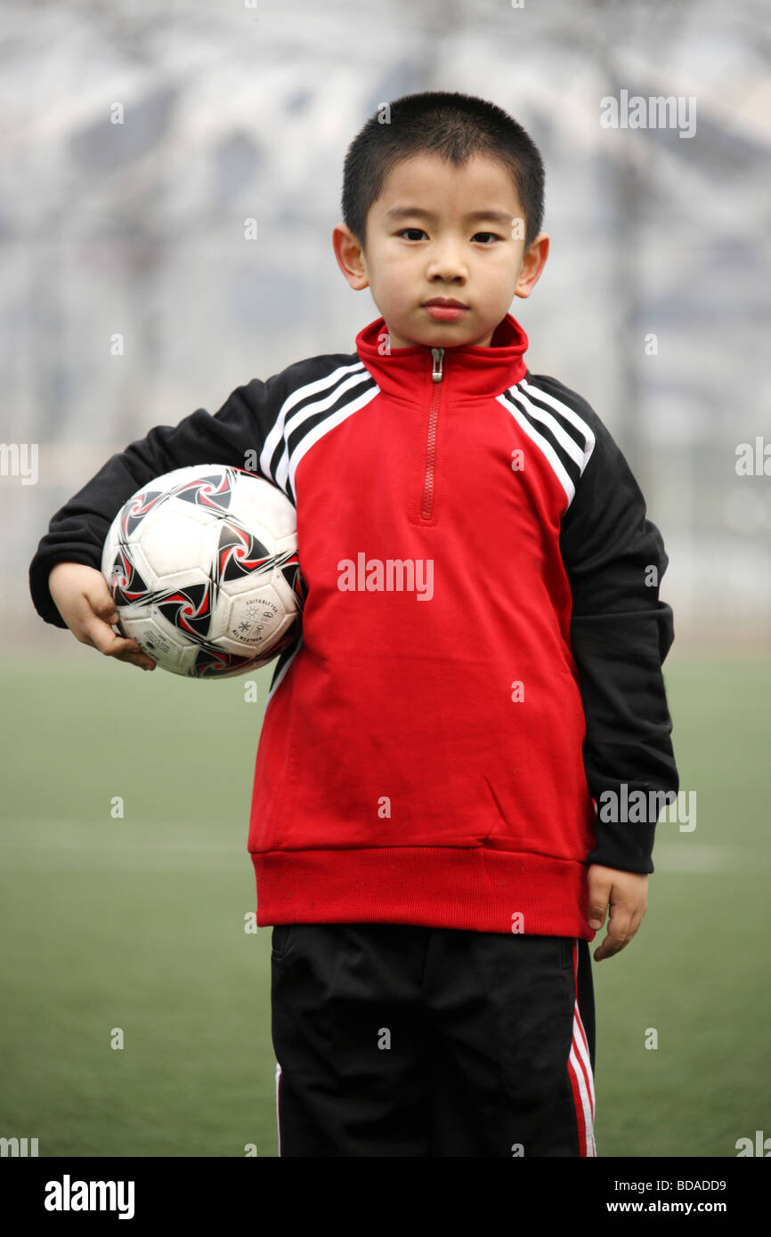 Chinese boy playing soccer on the field Stock Photo - Alamy
