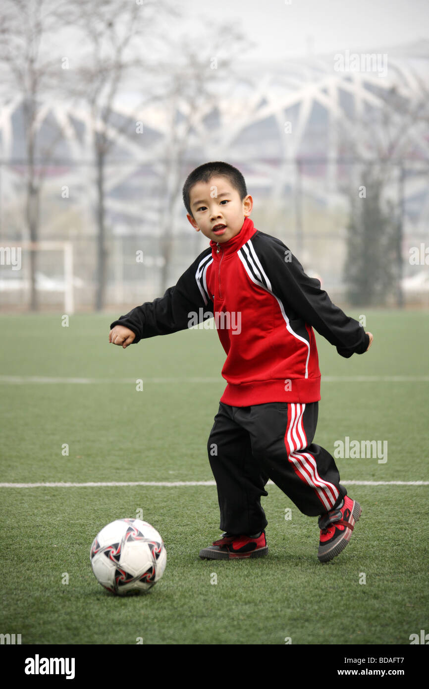 Chinese boy playing soccer on the field Stock Photo - Alamy