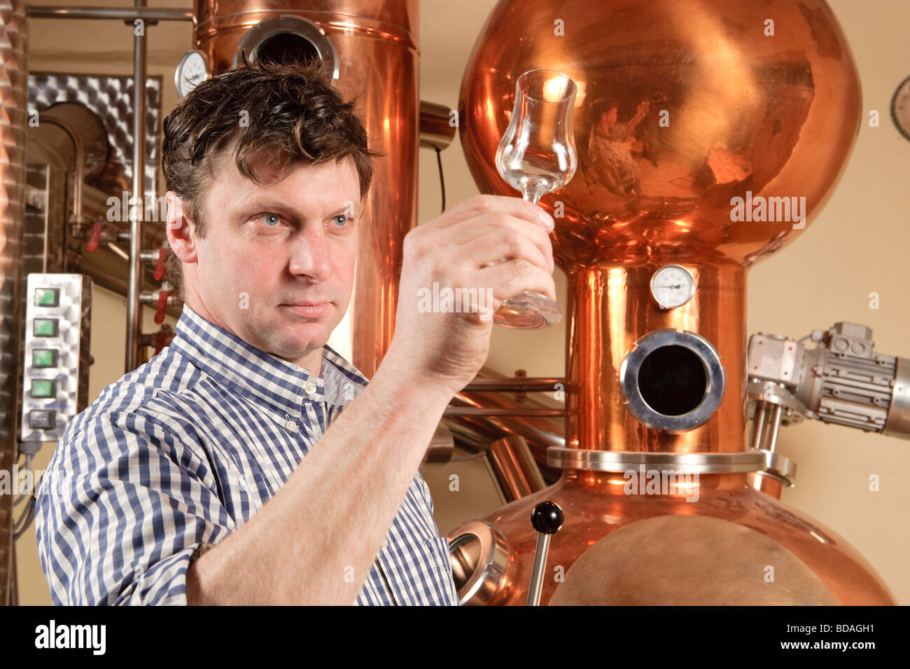 Man in front of distillery copper Stock Photo - Alamy