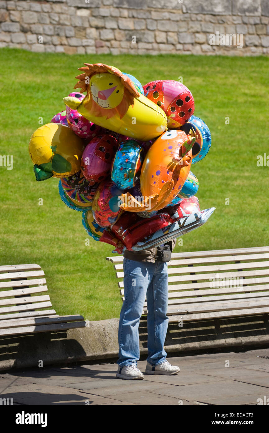 street vendor, a balloon seller with a bunch of balloons outside ...