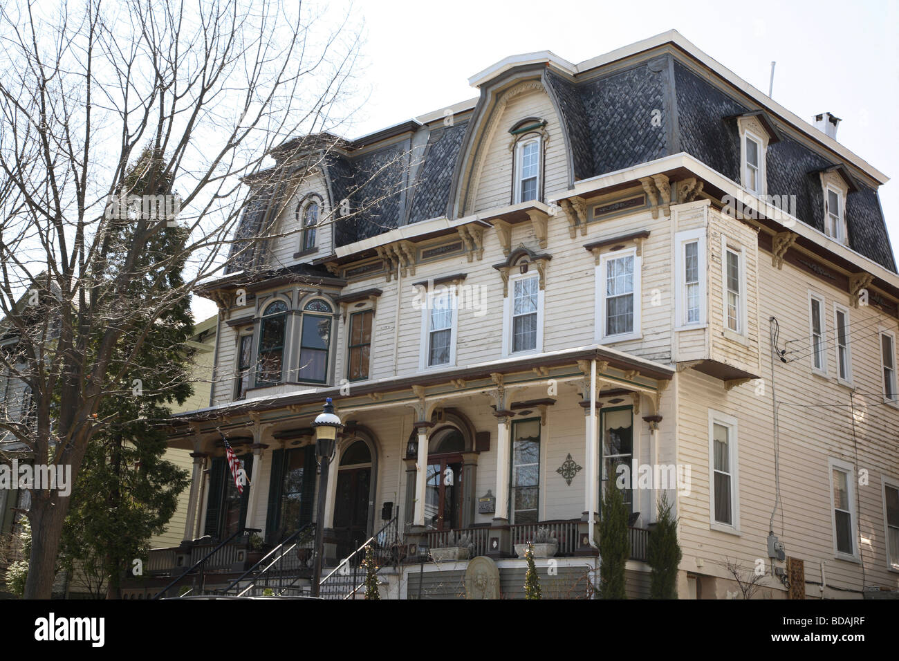 Large ornate beige shingled house with mansard roof Stock Photo - Alamy