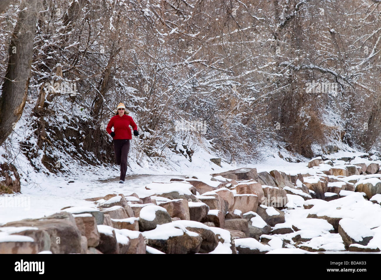 A female athlete runs along a trail in the foothills of the Rocky ...