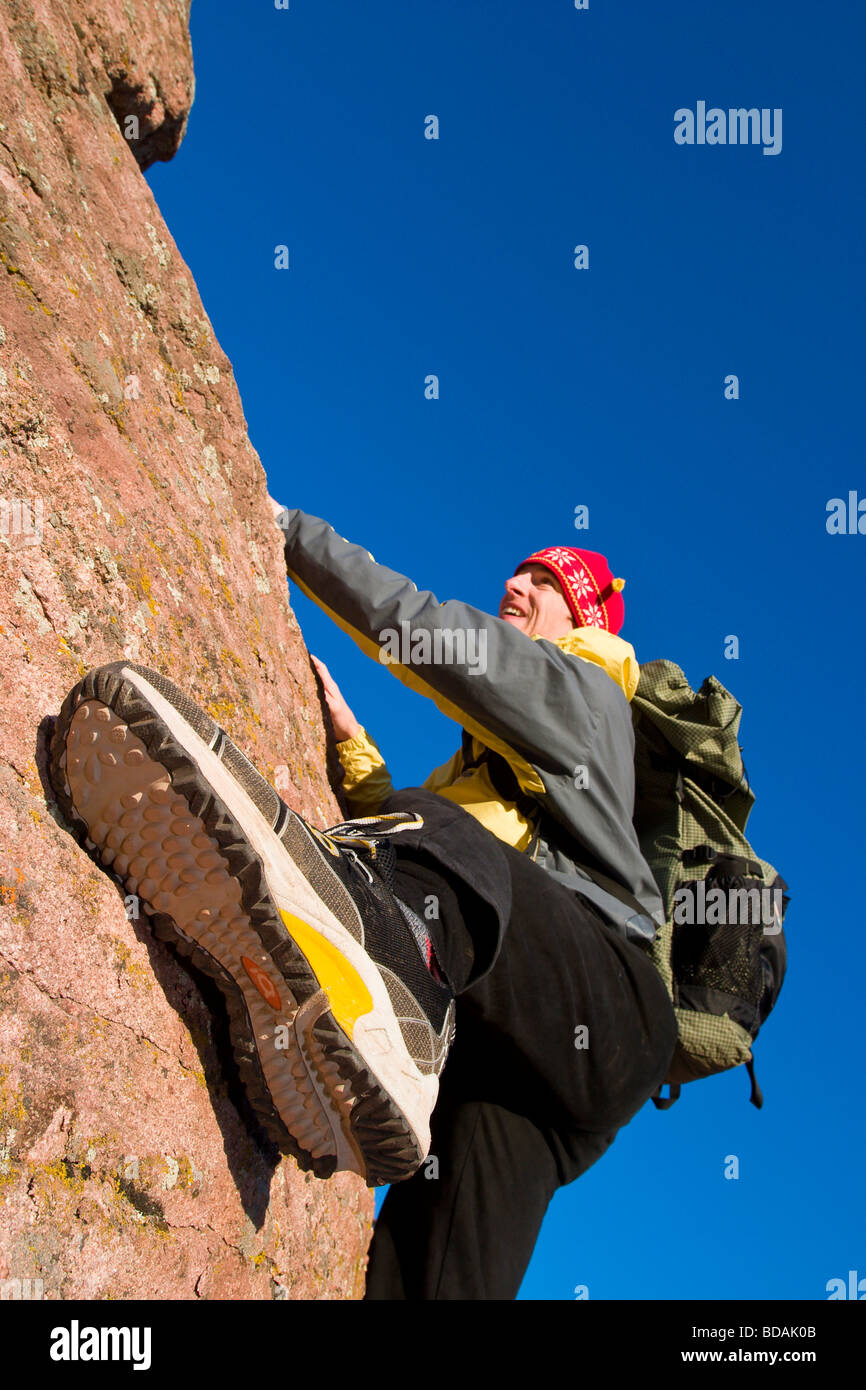 A male athlete climbs a boulder on the Red Rock Trail near Boulder ...
