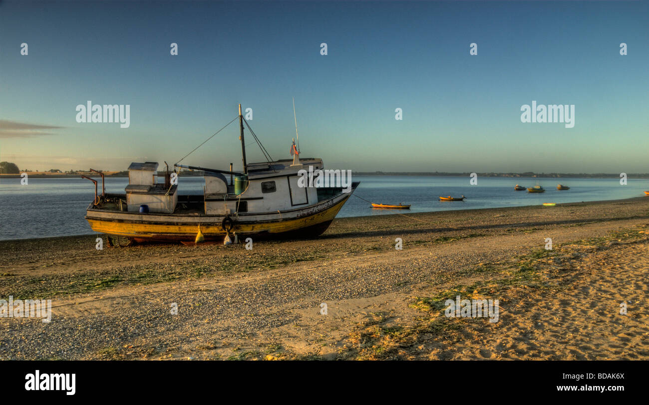 Small Fishing boat at shore at sunset Caulin Chiloe Island Chile Stock ...