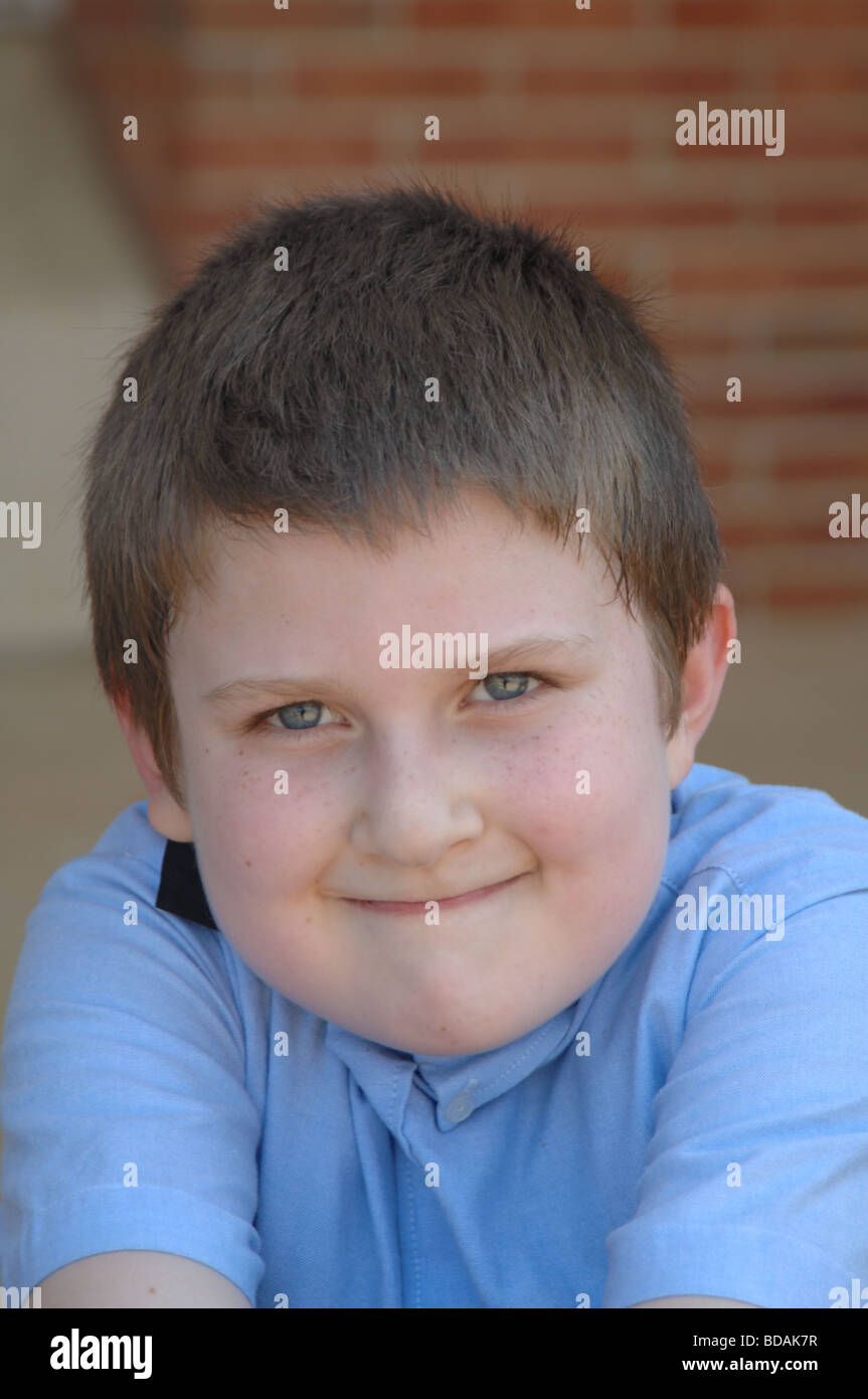 A innocent young lad's cute little face smiles a mischievous smile ...