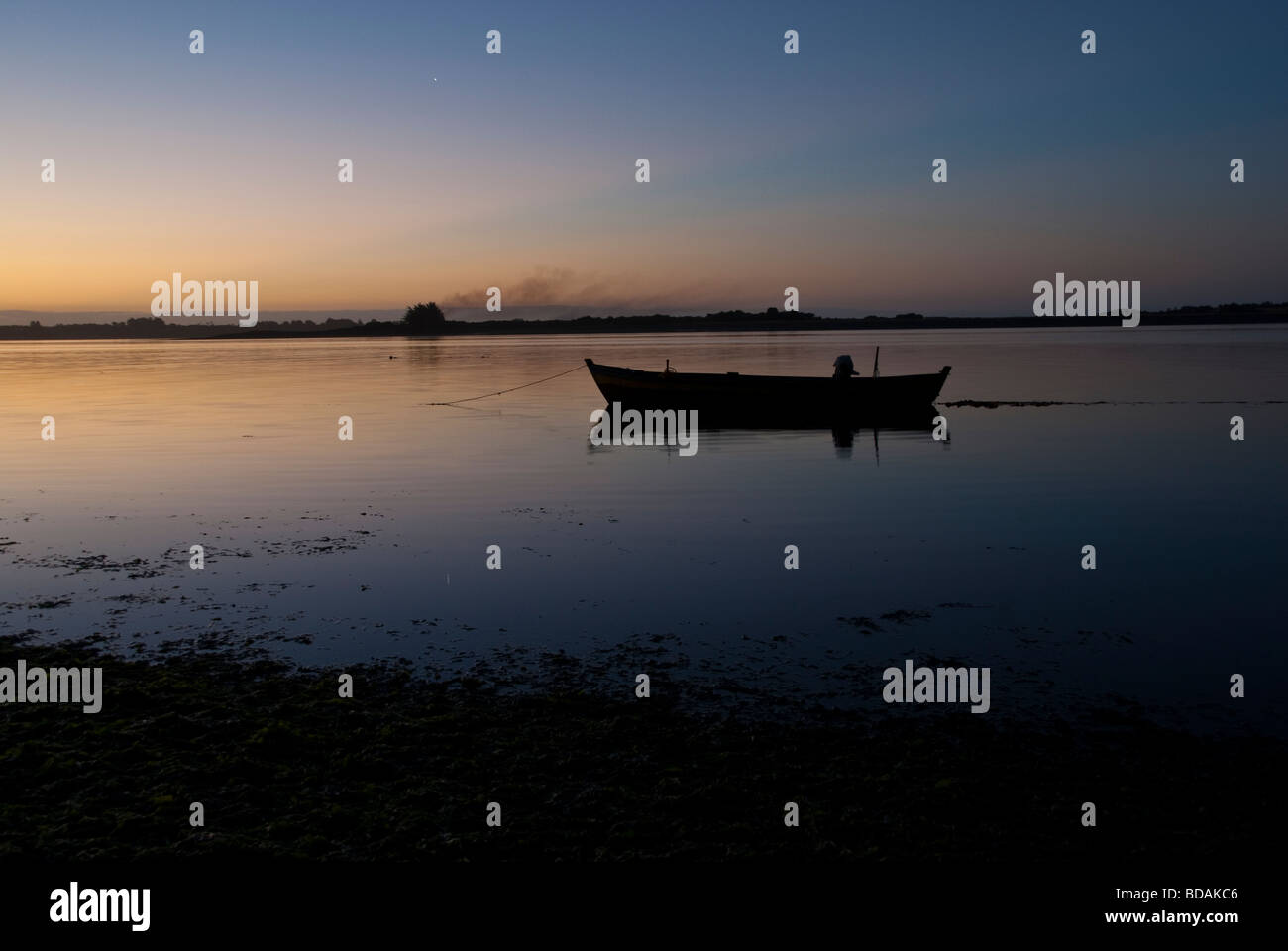 Small Fishing boat at shore at sunset Caulin Chiloe Island Chile Stock ...