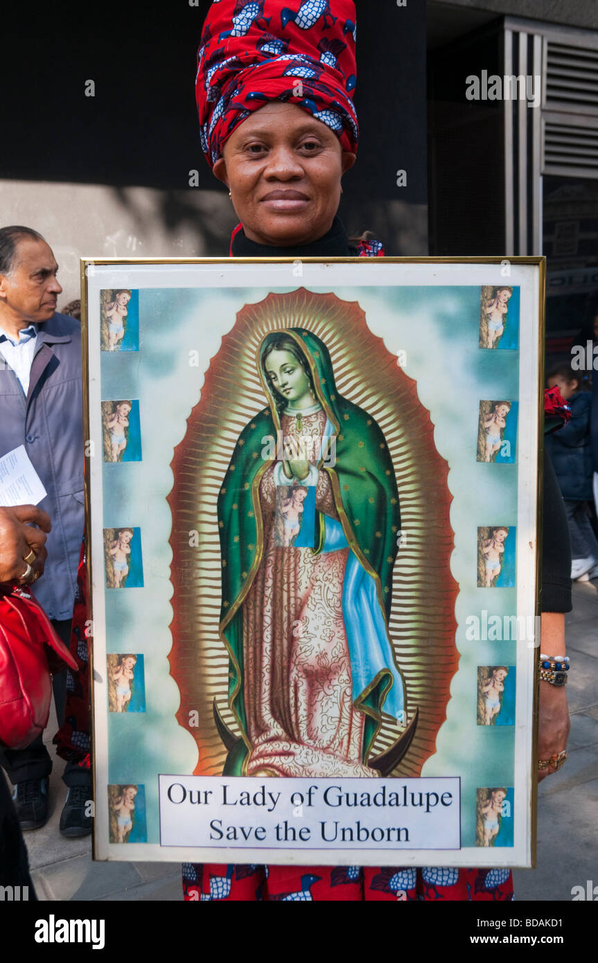 Black woman holds image of Our Lady of Guadalupe, Rosary Crusade of ...