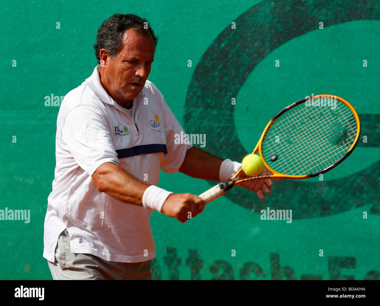 Elderly man playing a backhand at a tennis tournament Stock Photo - Alamy