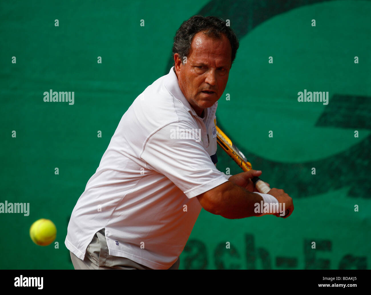 Elderly man playing a backhand at a tennis tournament Stock Photo - Alamy