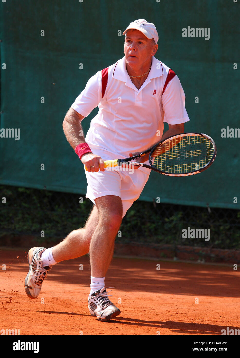 Elderly man playing a backhand at a tennis tournament Stock Photo - Alamy
