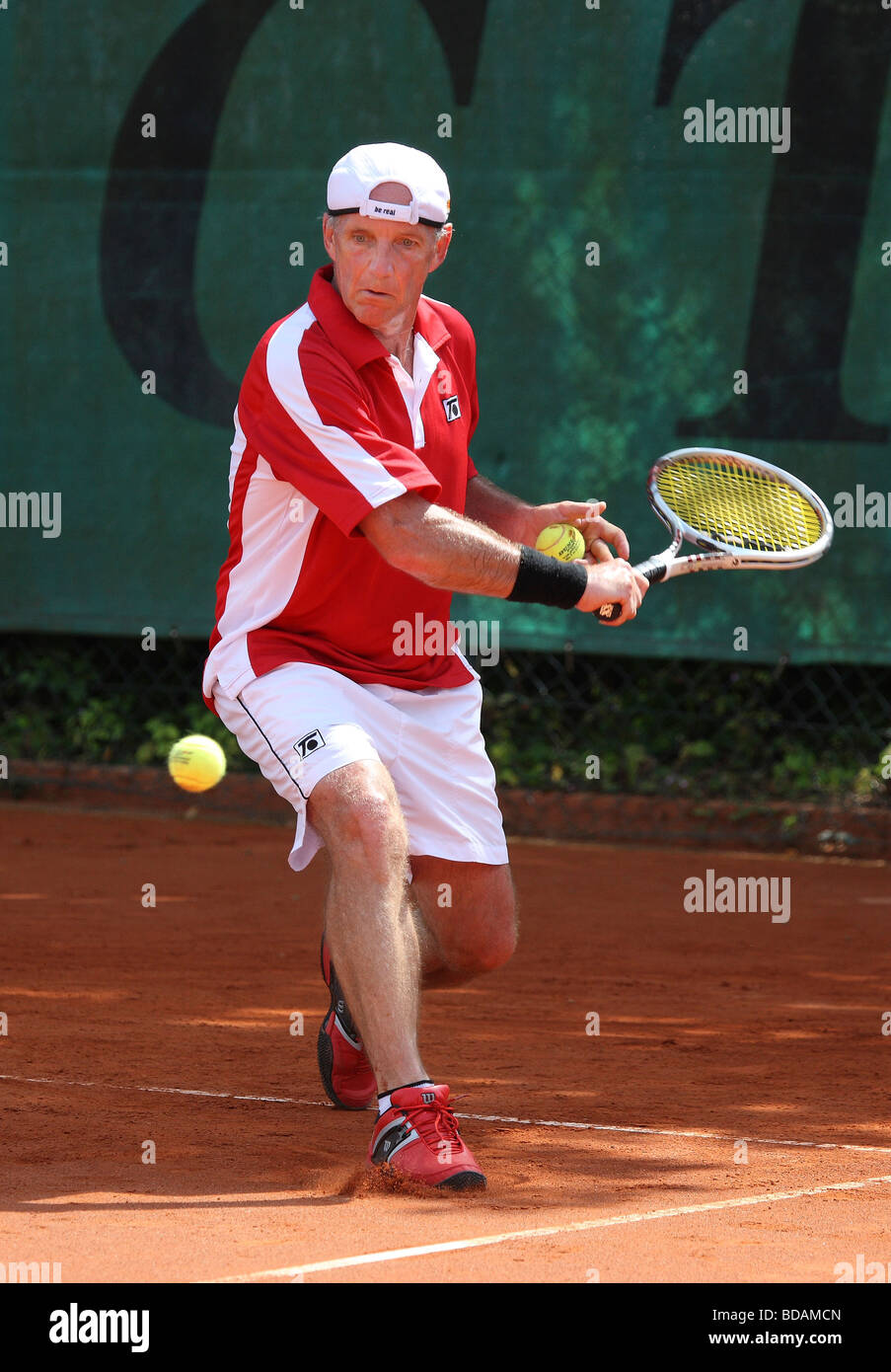 Elderly man playing a backhand at a tennis tournament Stock Photo - Alamy