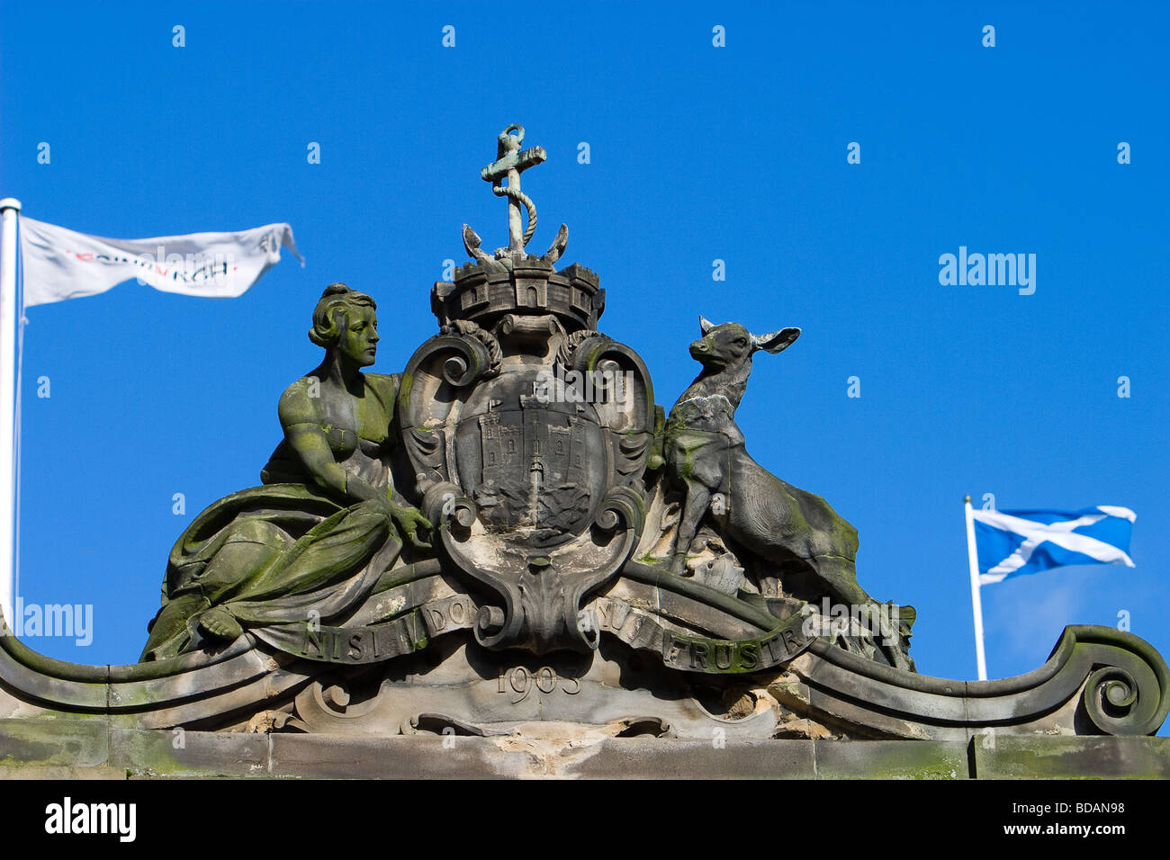 The flags of Scotland and Edinburgh fly next to a stone carving of the ...