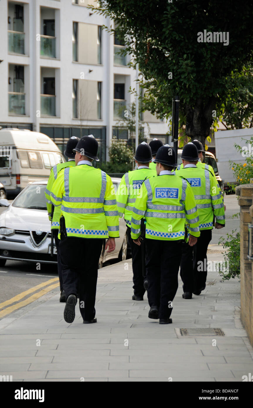 A group of metropolitan police officers walking along the street ...