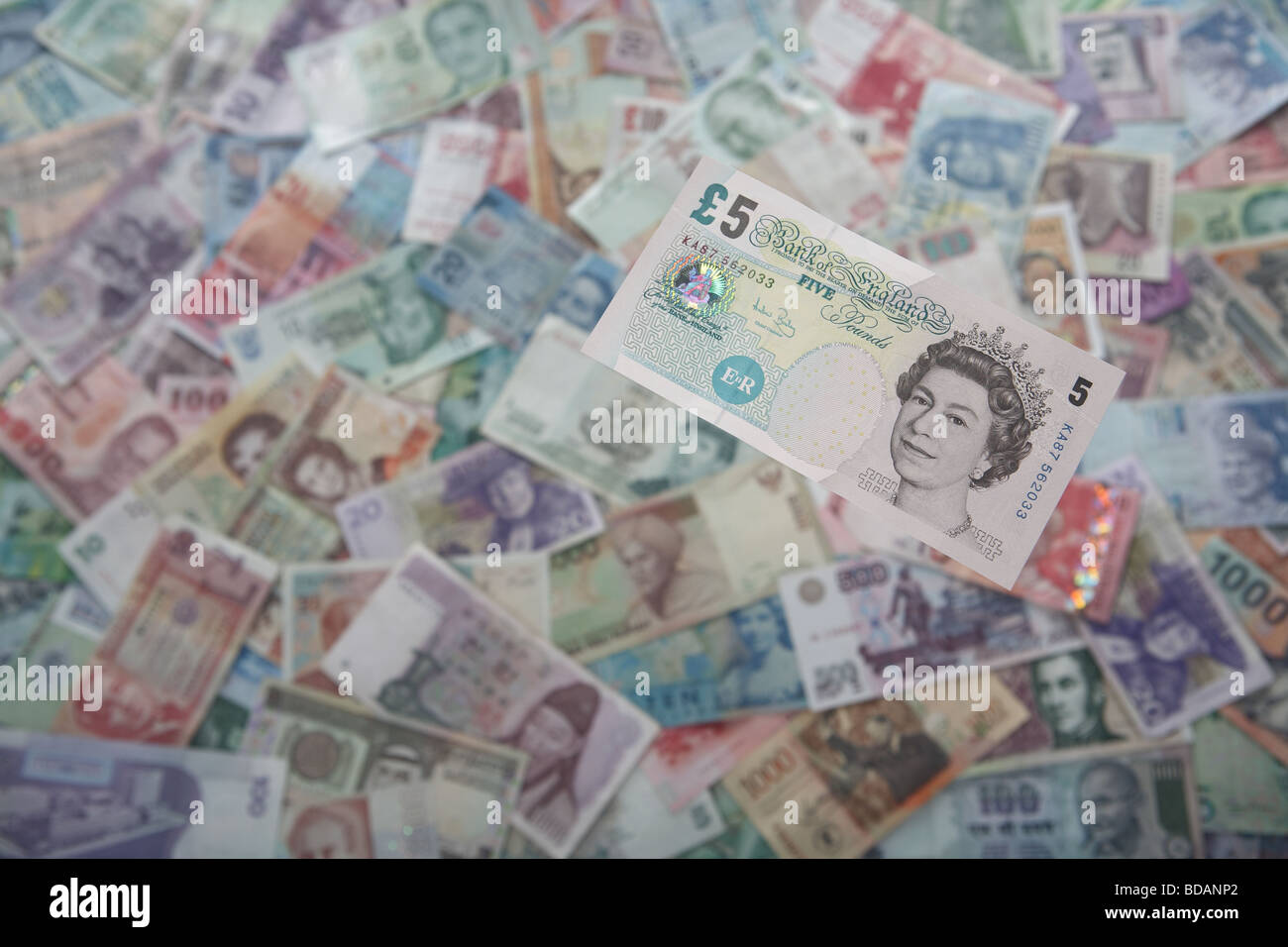 A British Five British Pound note on a soft background of international ...