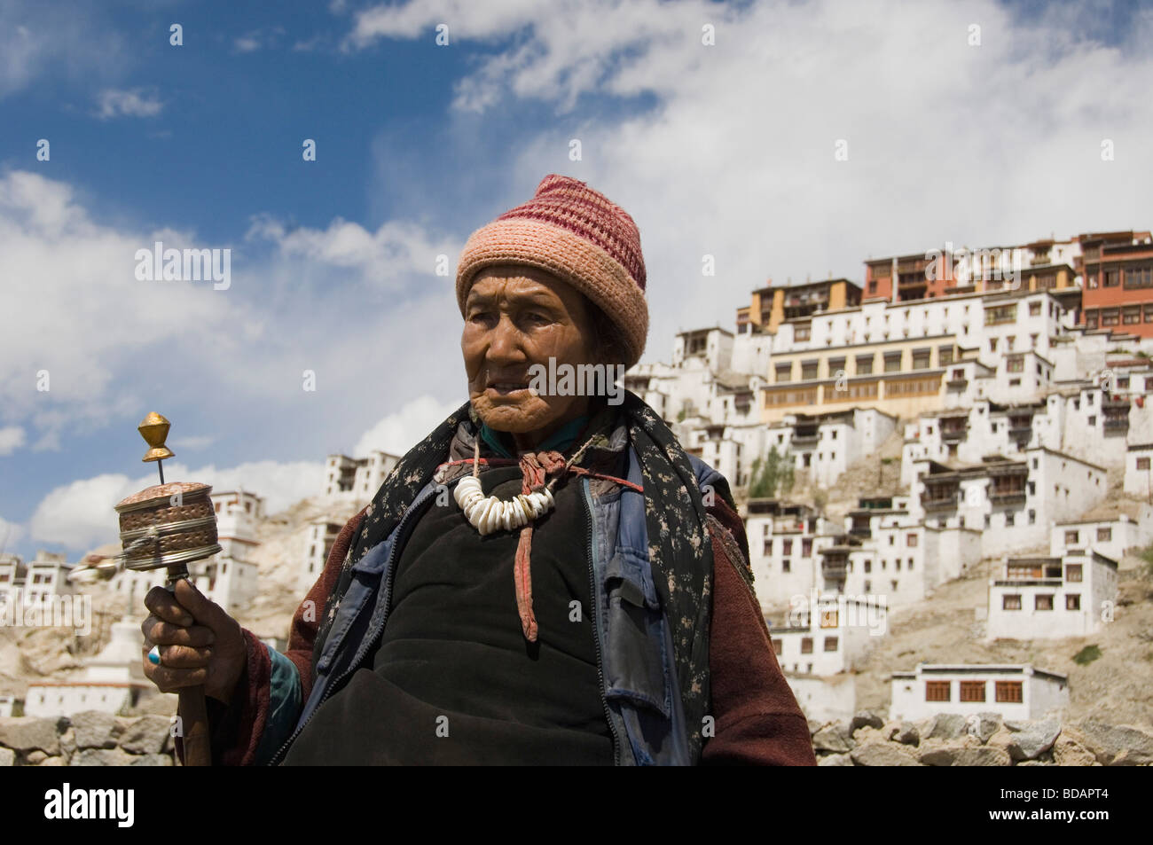 Woman praying with monastery in the background, Thiksey Monastery ...