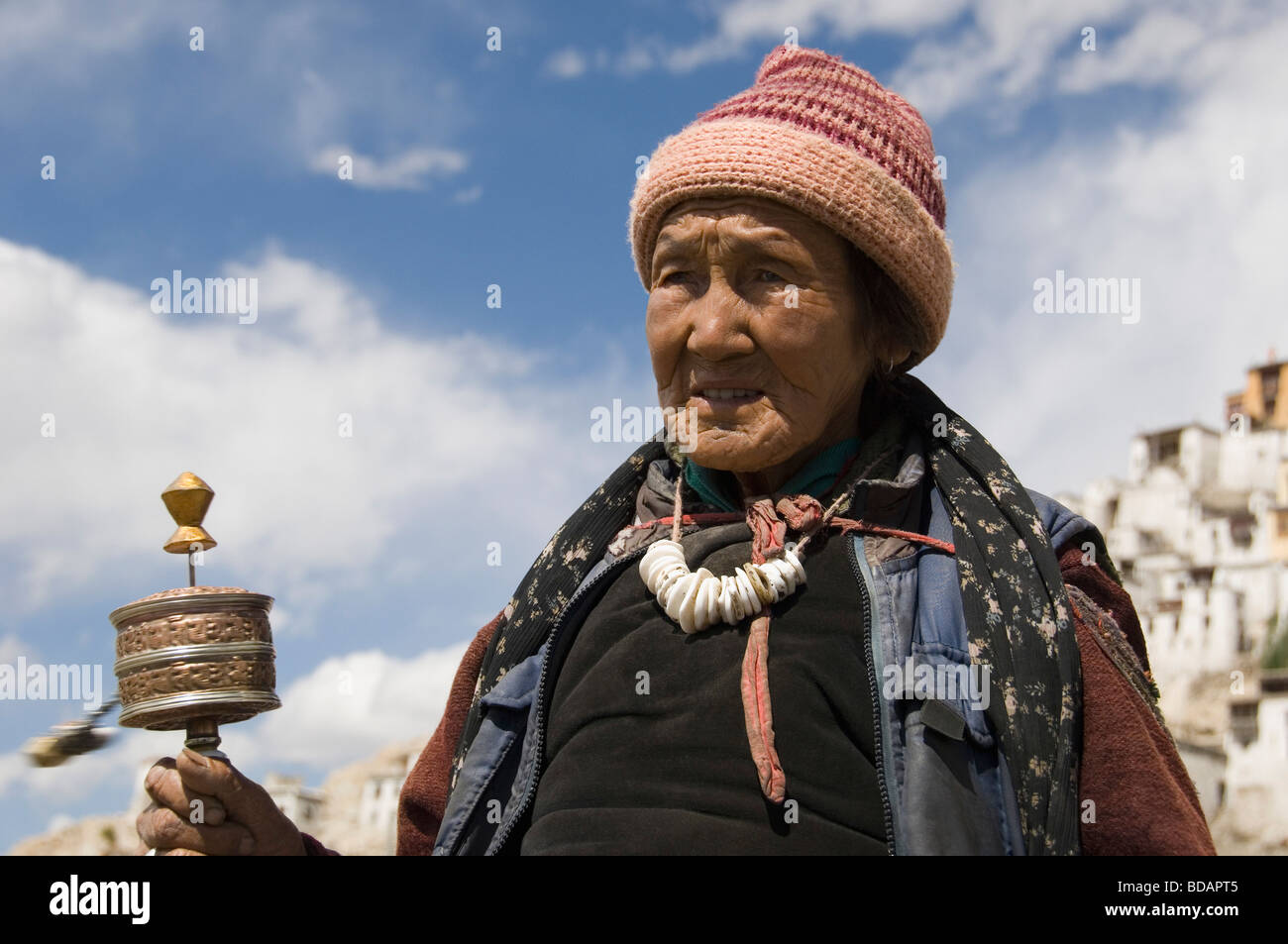 Woman praying with monastery in the background, Thiksey Monastery ...