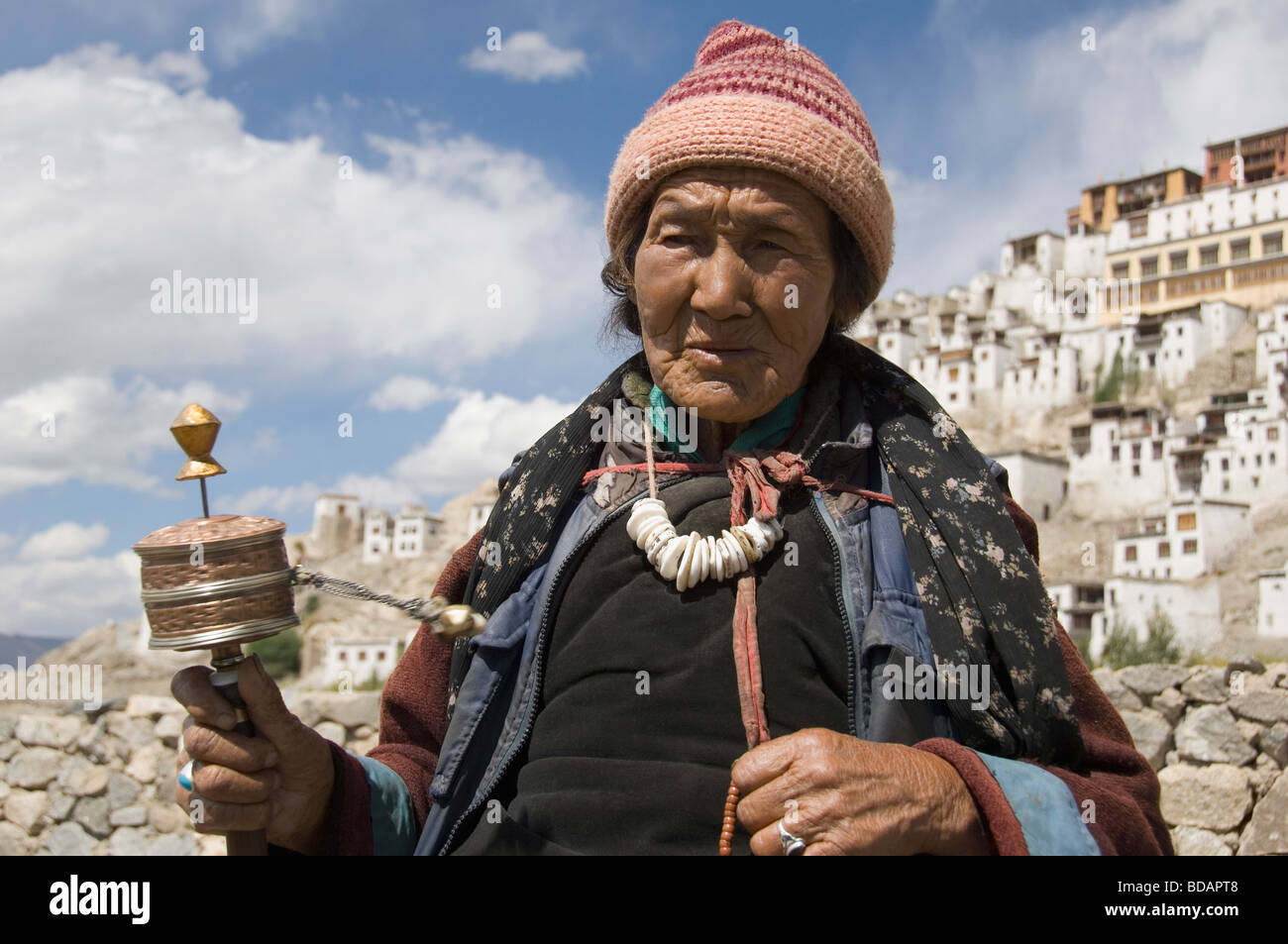 Woman praying with monastery in the background, Thiksey Monastery ...