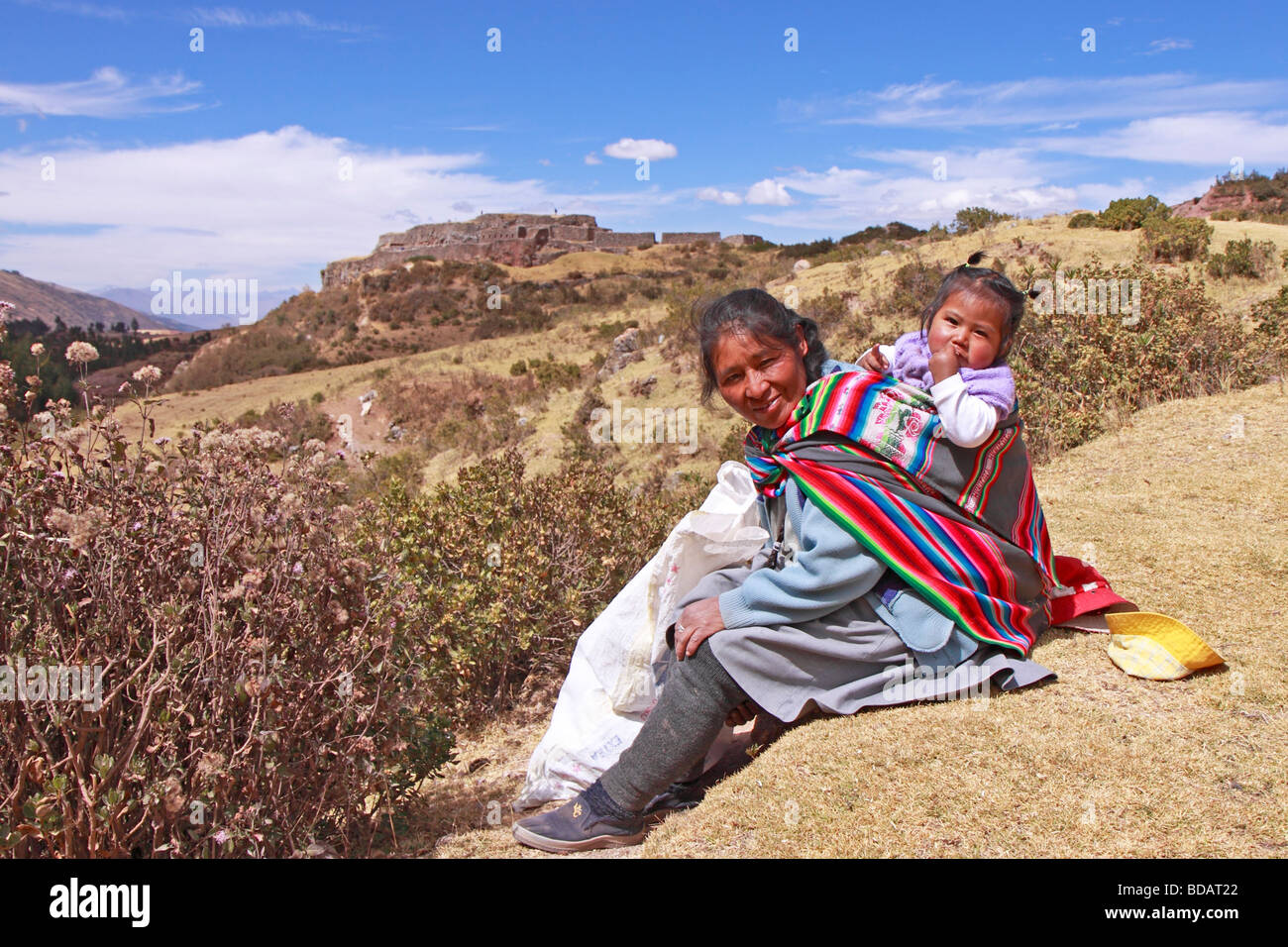 native woman with young child sitting in front of Inca Ruins of Puca ...