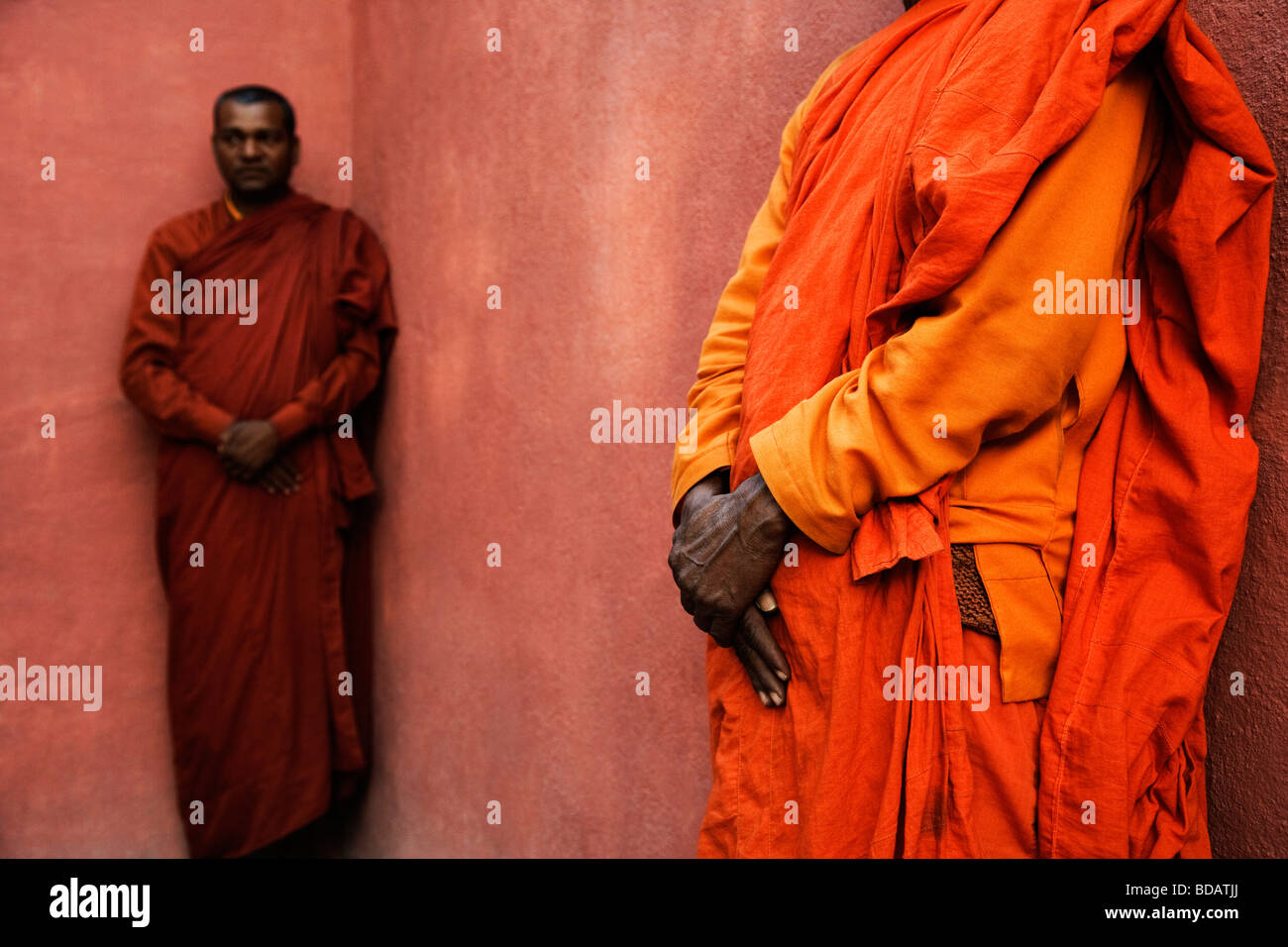 Two monks leaning against a wall, Bodhgaya, Gaya, Bihar, India Stock ...