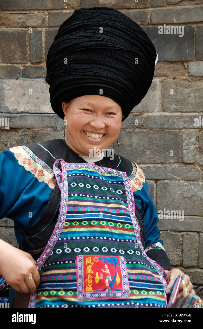 Portrait of happy female trader showing clothes Ancient Town of ...