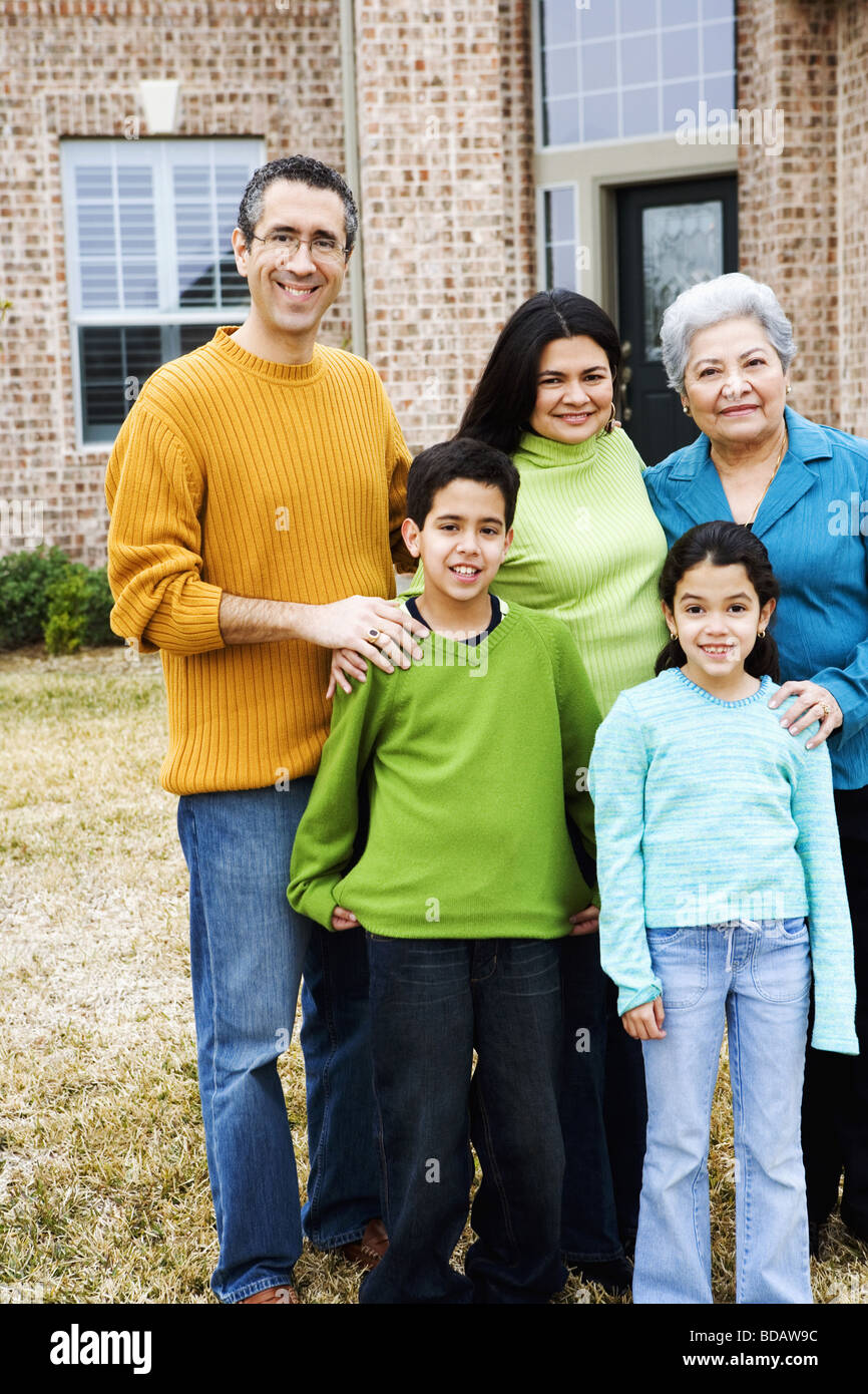 Family standing in front of a house and smiling Stock Photo - Alamy