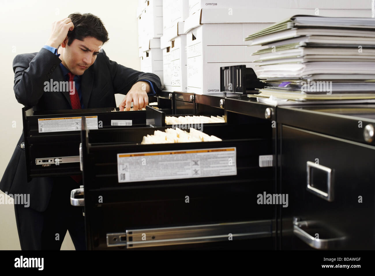 Businessman searching files in a filling cabinet Stock Photo - Alamy