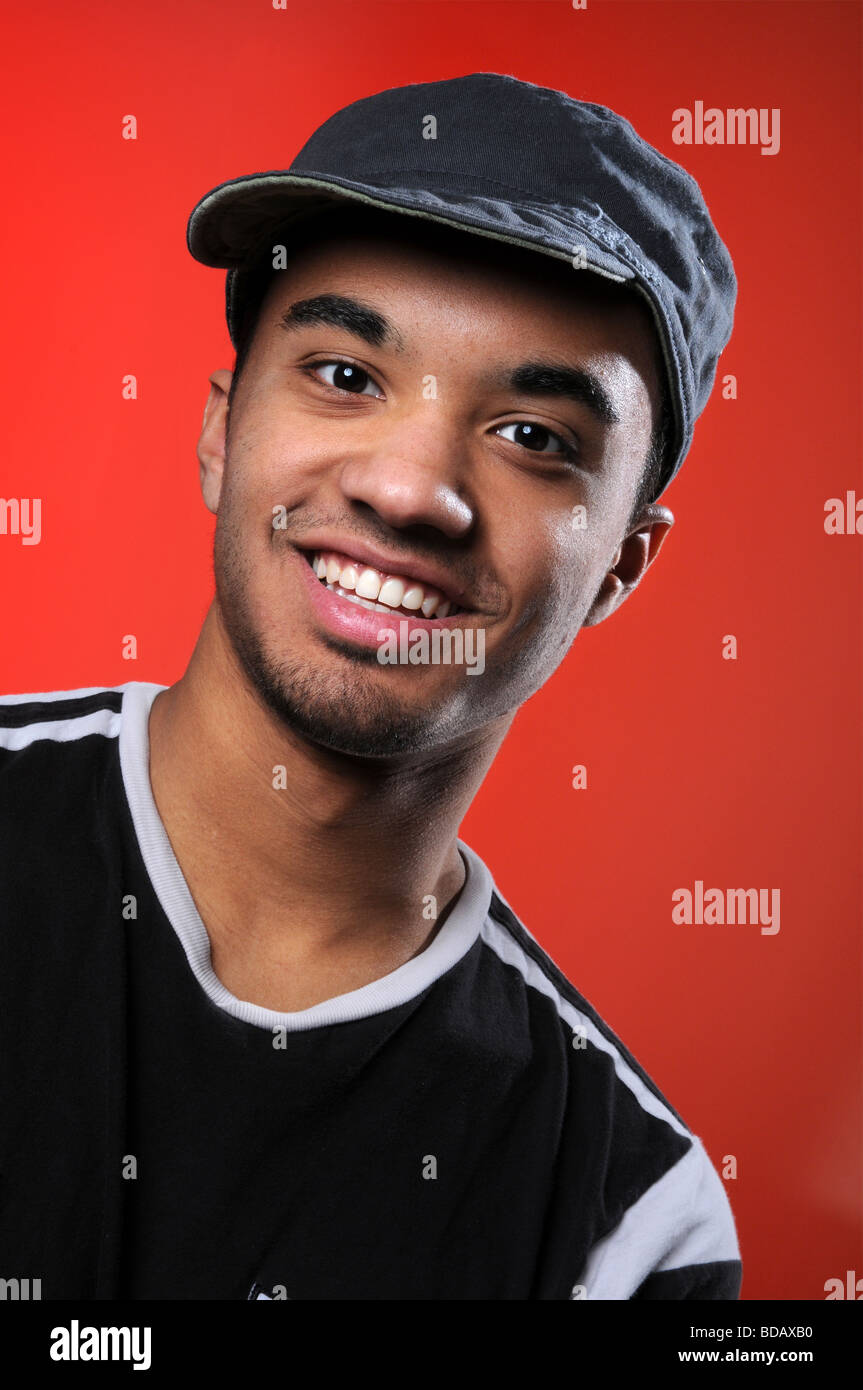 Portrait of young man smiling over a red background Stock Photo - Alamy