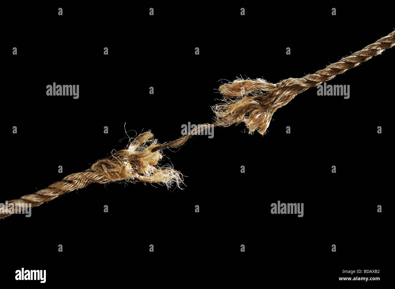 Frayed rope about to break isolated over black background Stock Photo ...