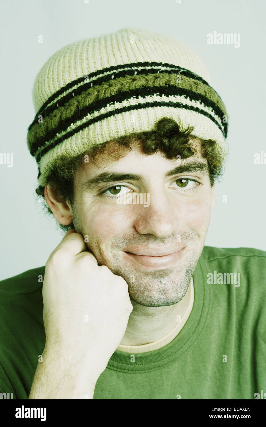 Portrait of a young man grinning with his hand on his chin Stock Photo ...