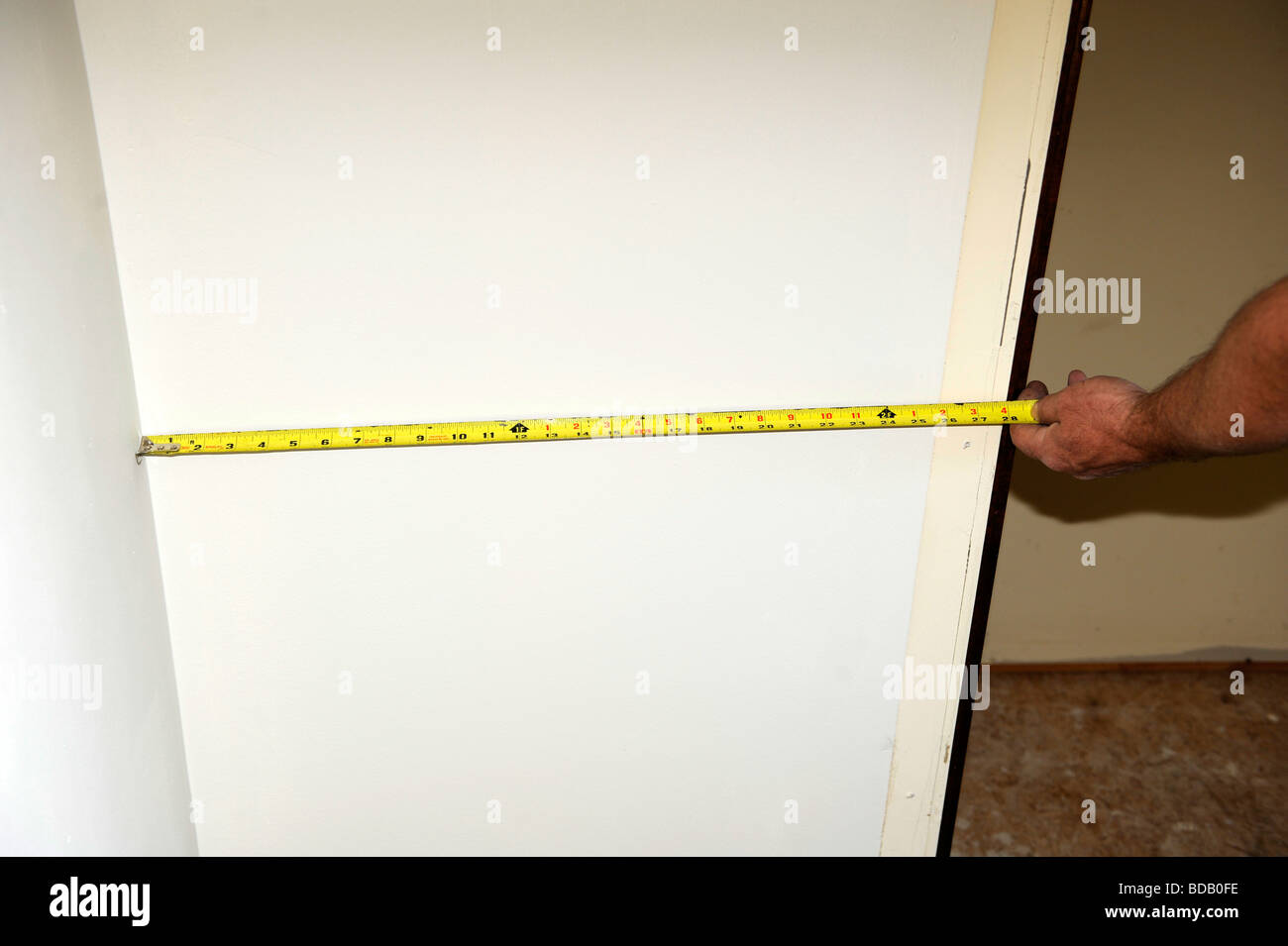 Carpenter uses tape measure to calculate distance Stock Photo - Alamy