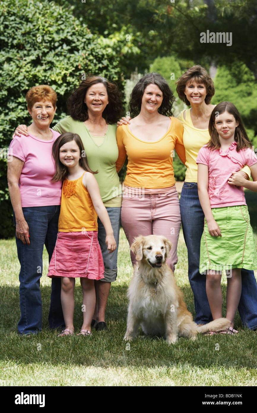 Family members standing with their dog Stock Photo - Alamy