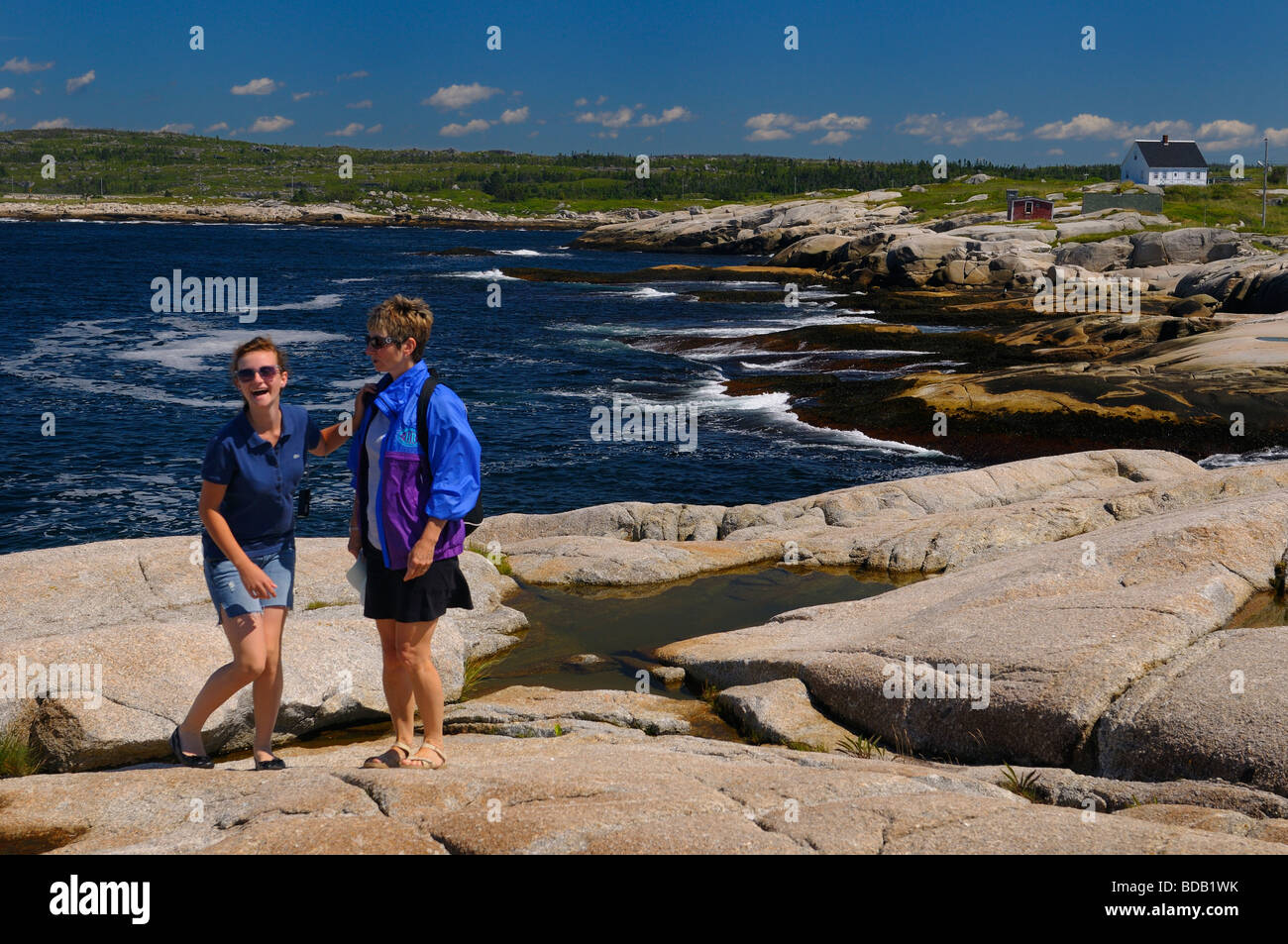 Mother and laughing daughter tourists on the granite rocks of Peggy's ...