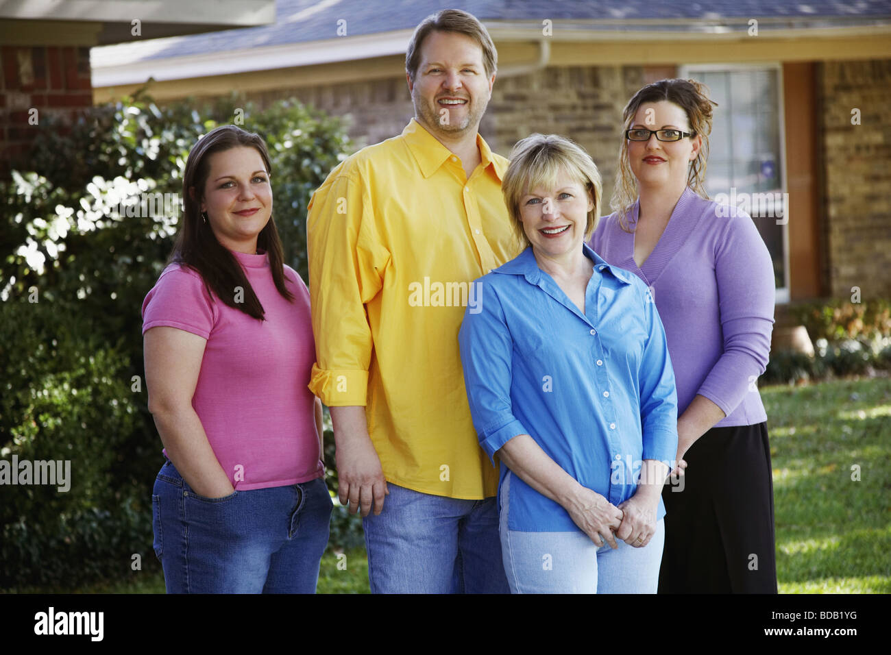 Portrait of four people standing together and smiling Stock Photo - Alamy