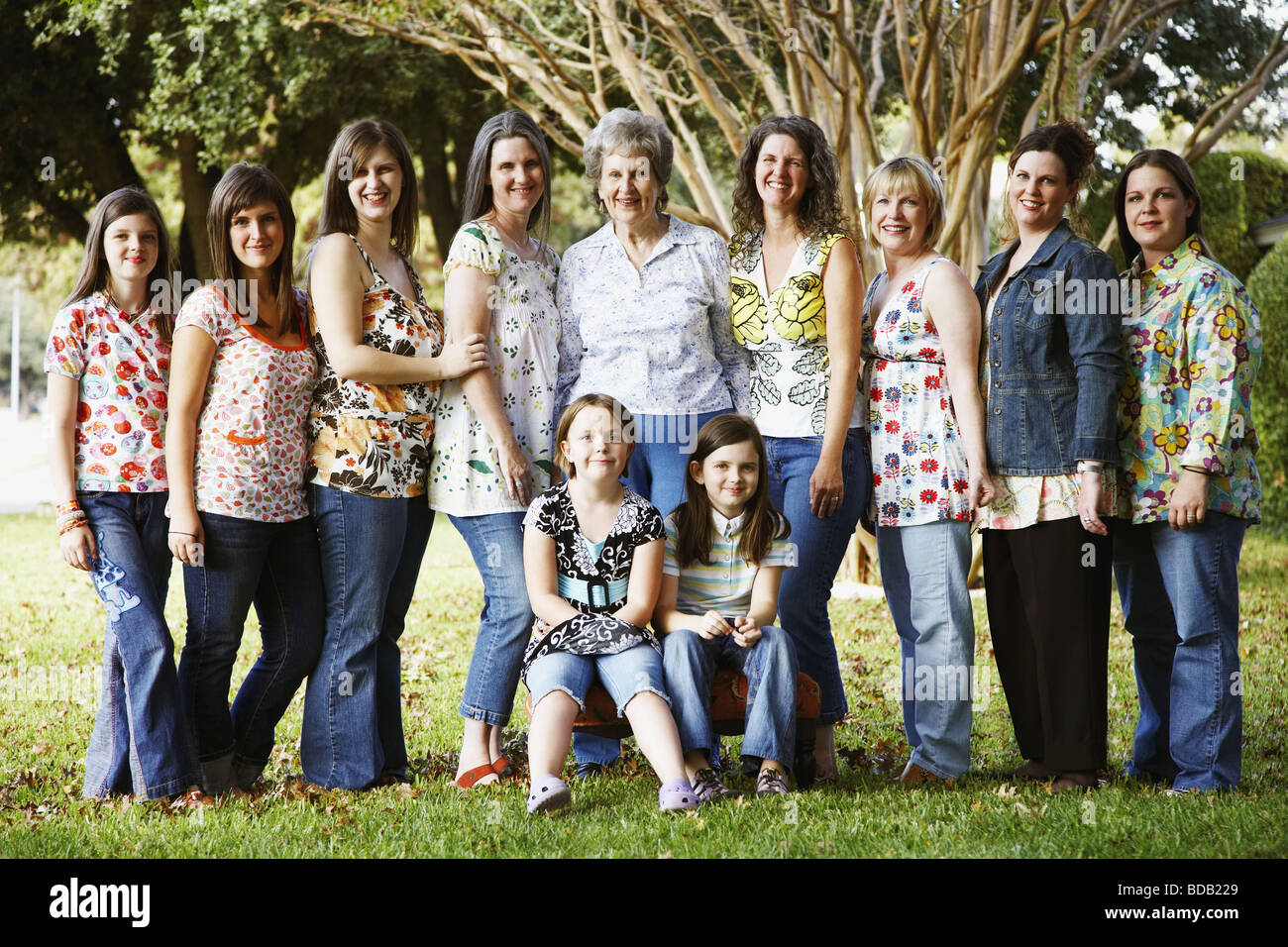 Portrait of a family standing in a row in a lawn Stock Photo - Alamy