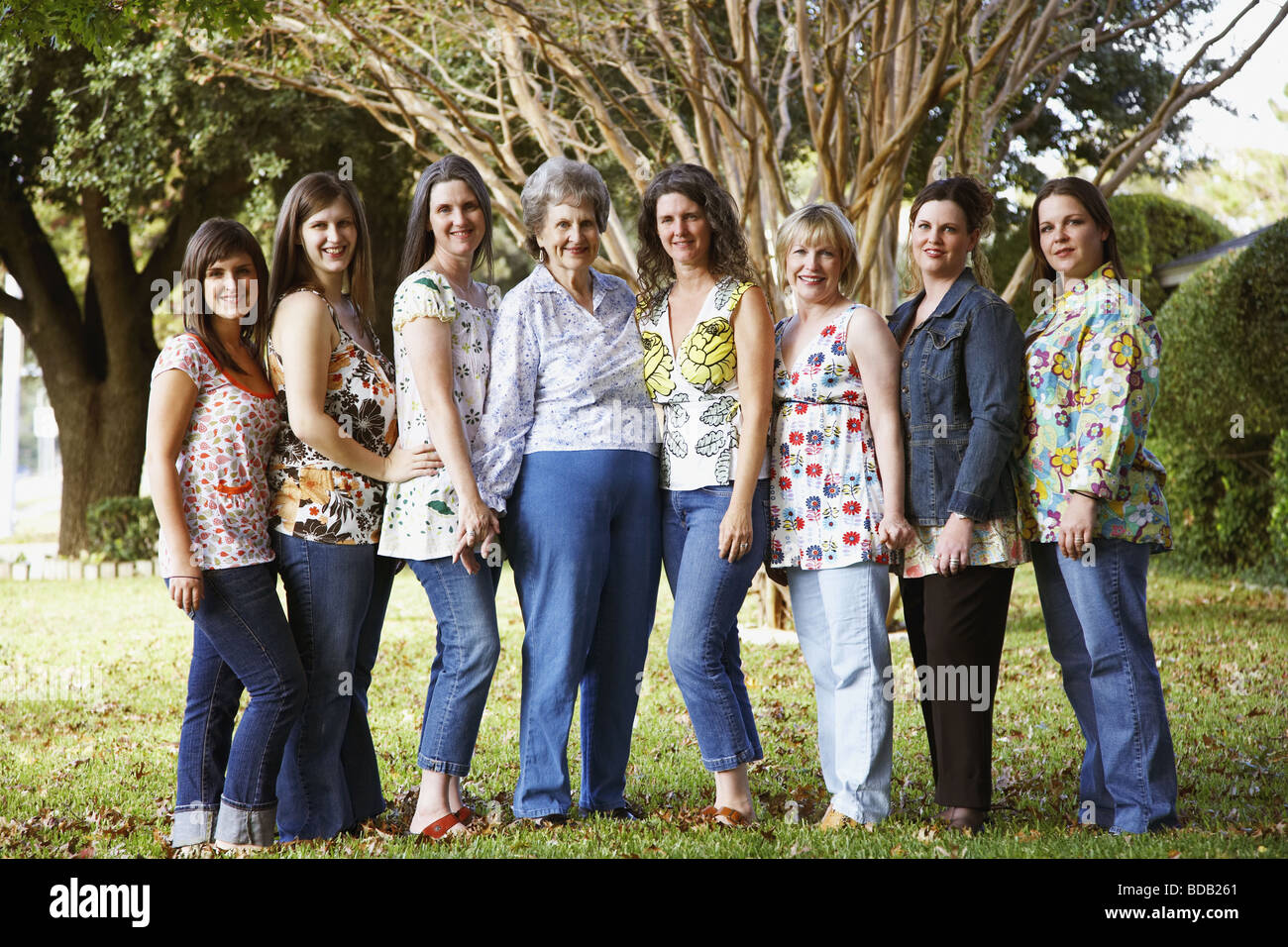 Portrait of a family standing in a row in a lawn Stock Photo - Alamy