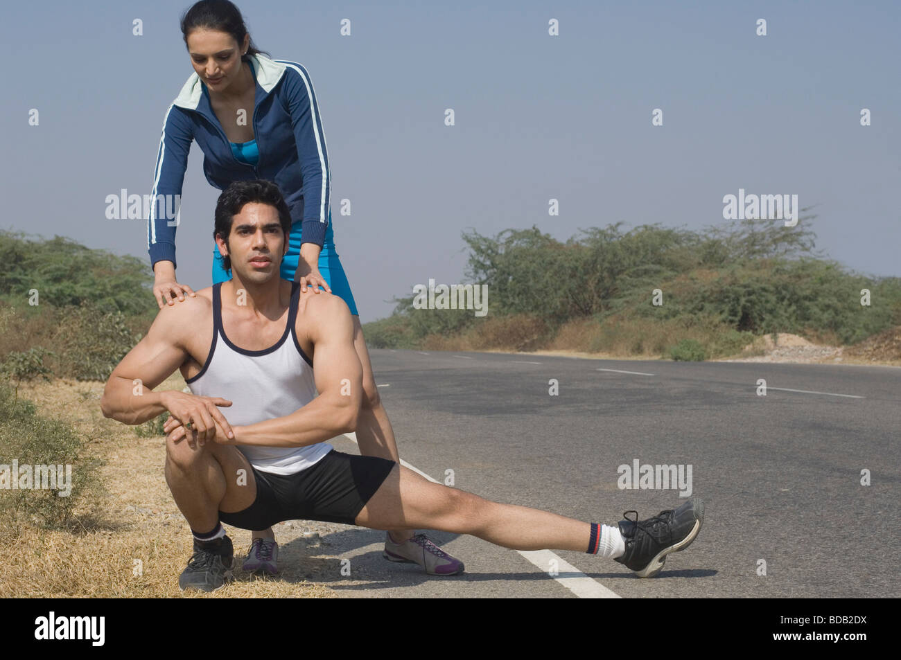 Woman helping a man in stretching Stock Photo - Alamy