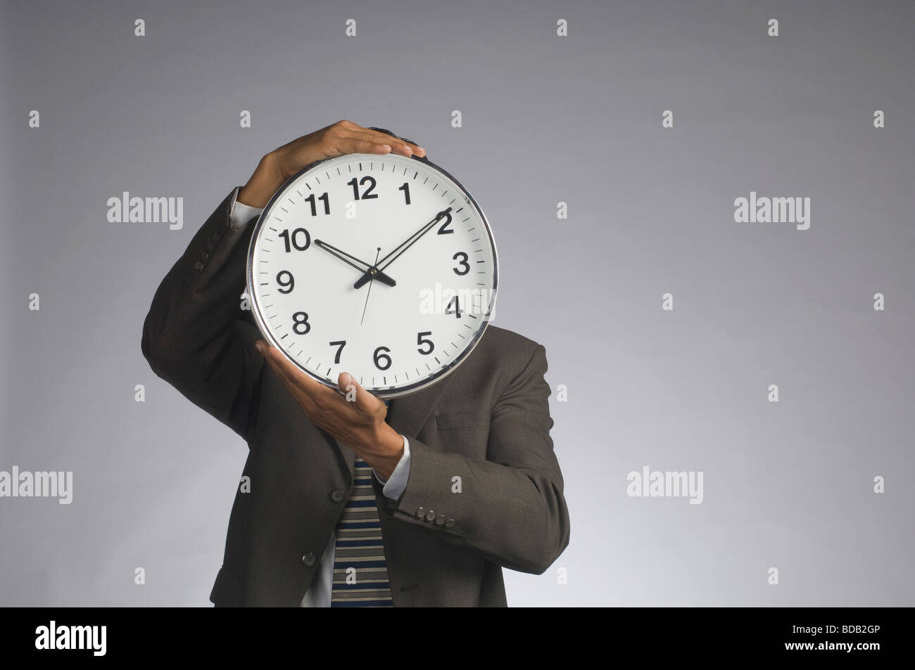 Businessman hiding his face with a clock Stock Photo - Alamy