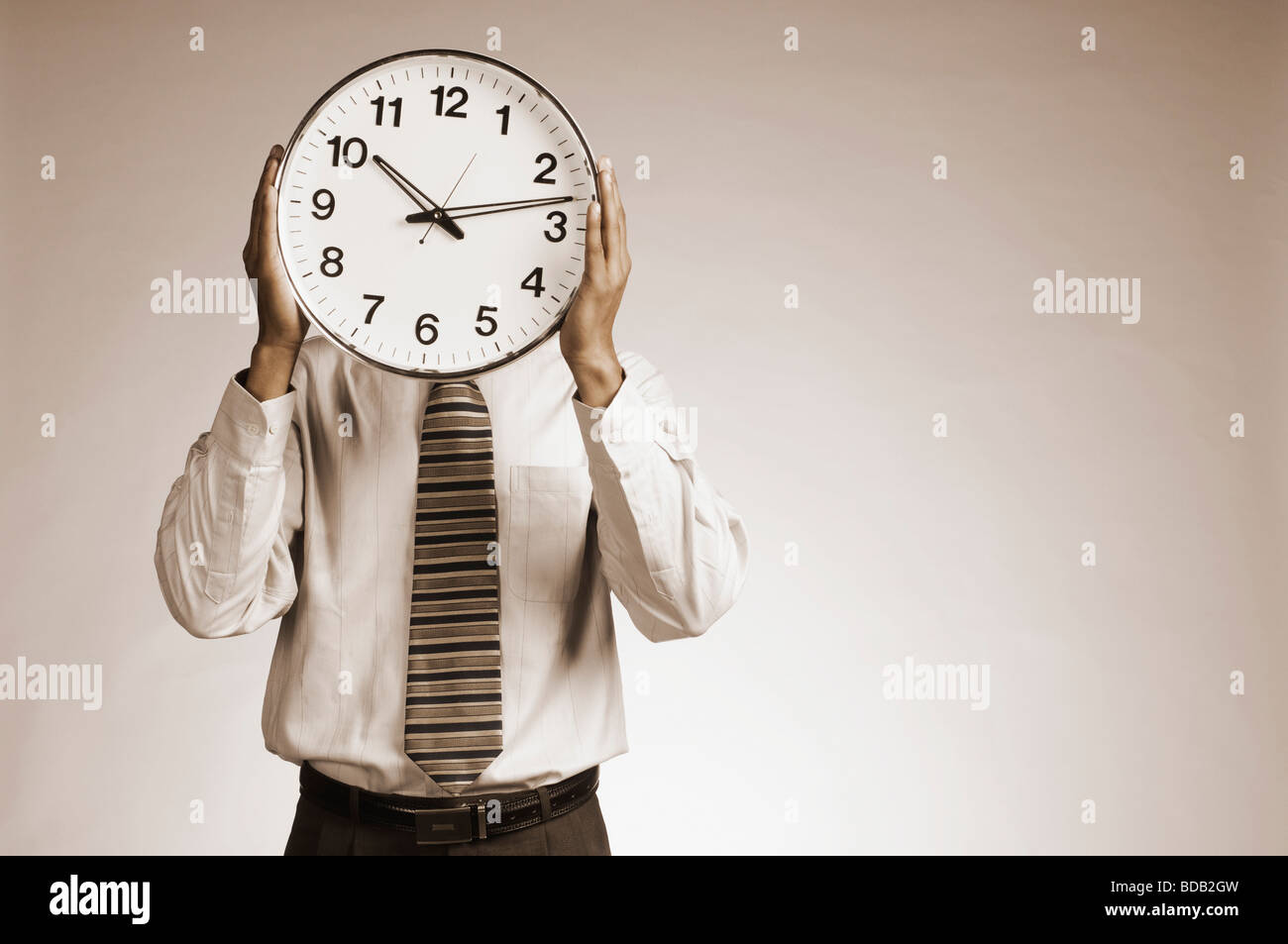 Businessman hiding his face with a clock Stock Photo - Alamy