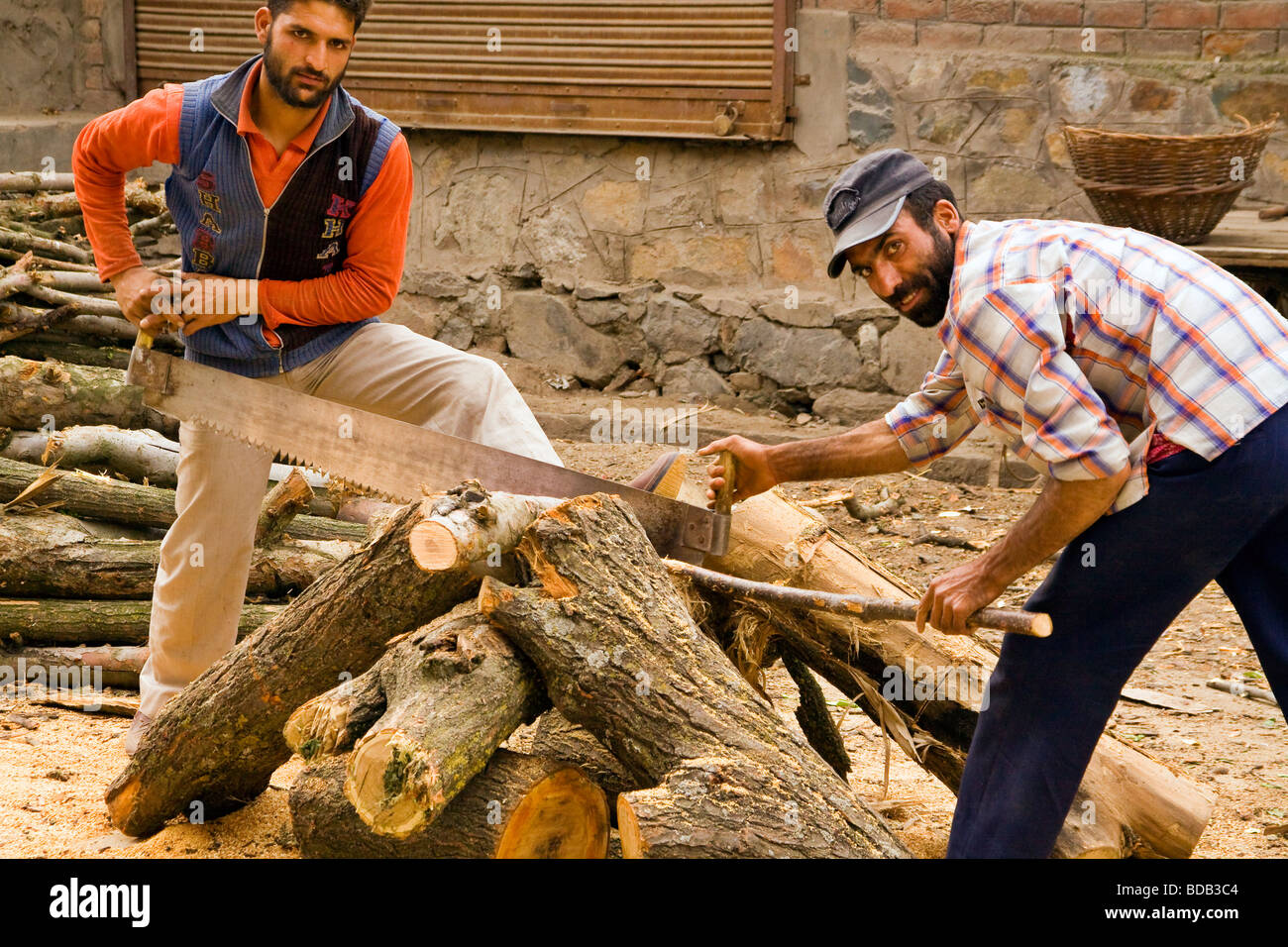 Two men sawing a tree trunk using a traditional saw in Srinagar Old ...