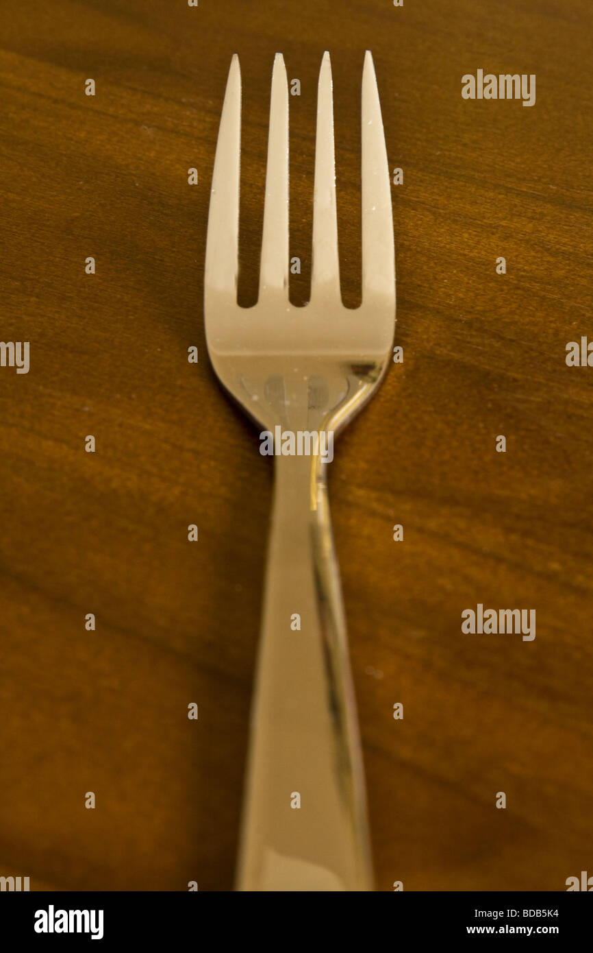 A single fork on a wooden table Stock Photo - Alamy