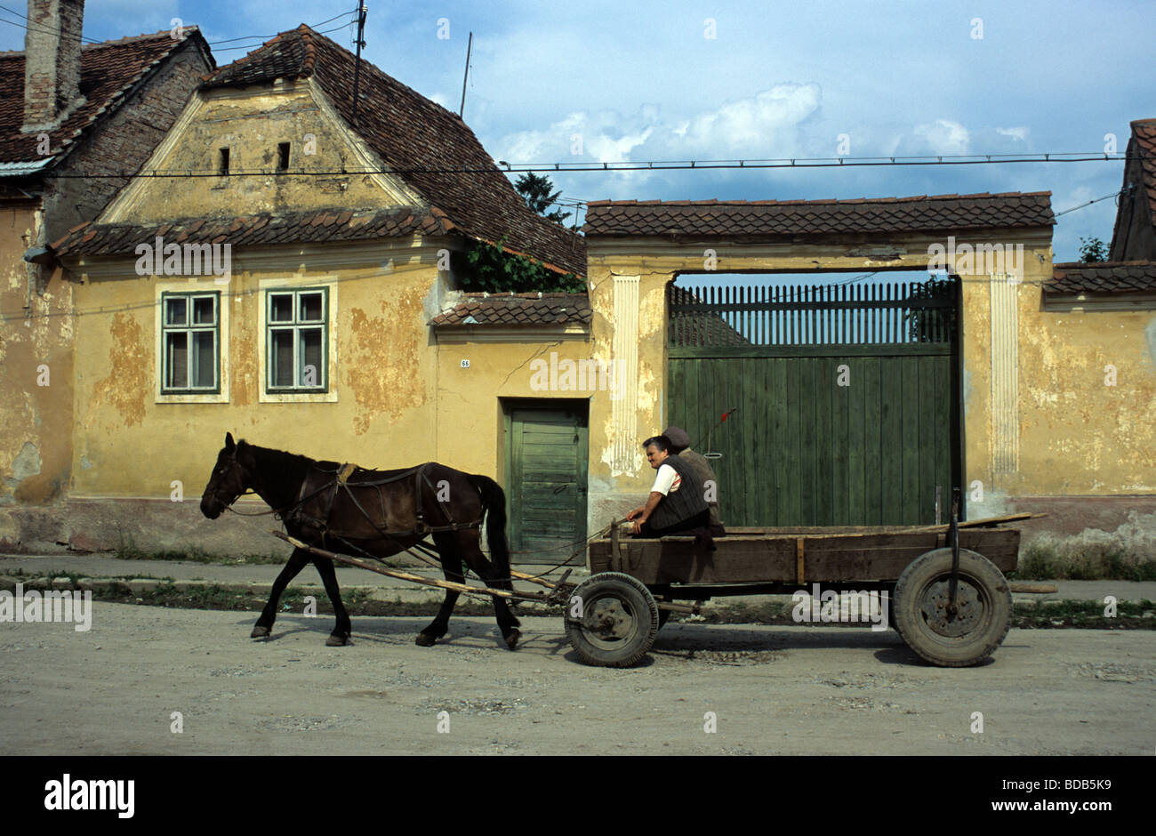 Village Scene with Traditional Saxon House & a Romanian Couple Riding a ...