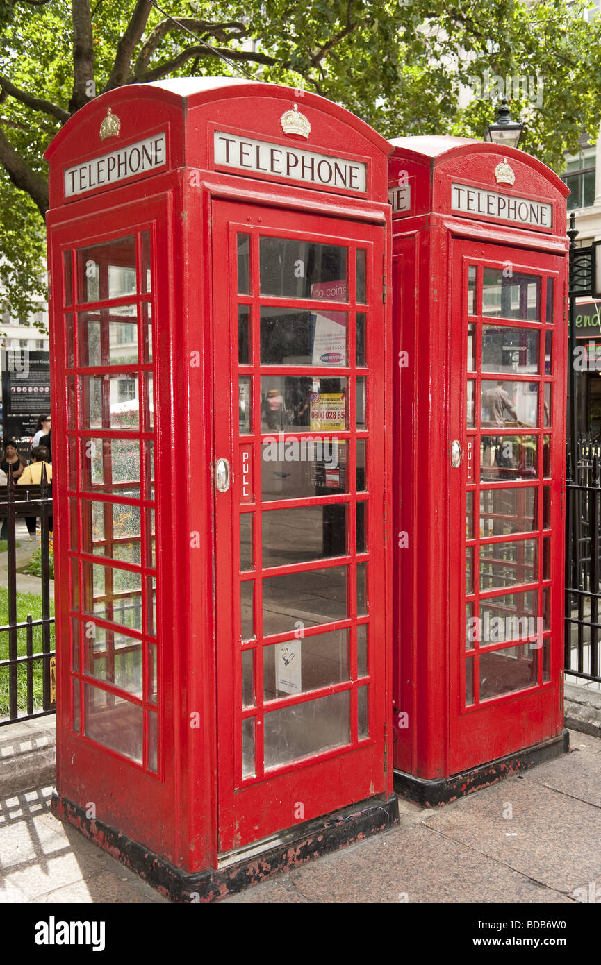 Two traditional British red public telephone / phone boxes standing ...