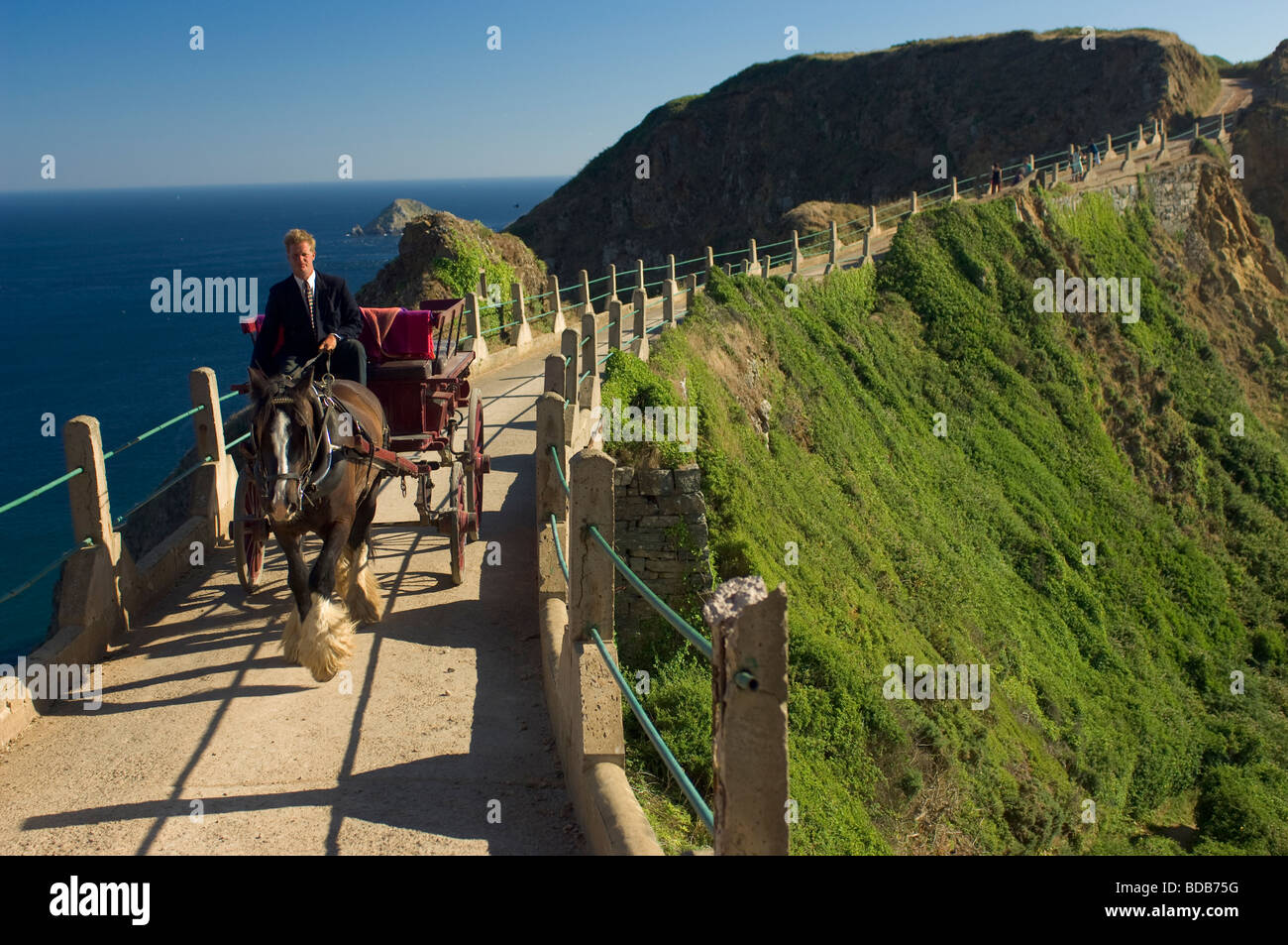 Horse carriage crossing the narrow isthmus of La Coupée Island of Sark ...