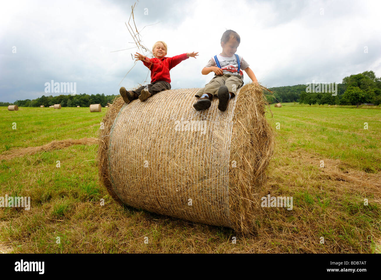 2 3 4 years old children boys playing on field with hay bale Stock ...