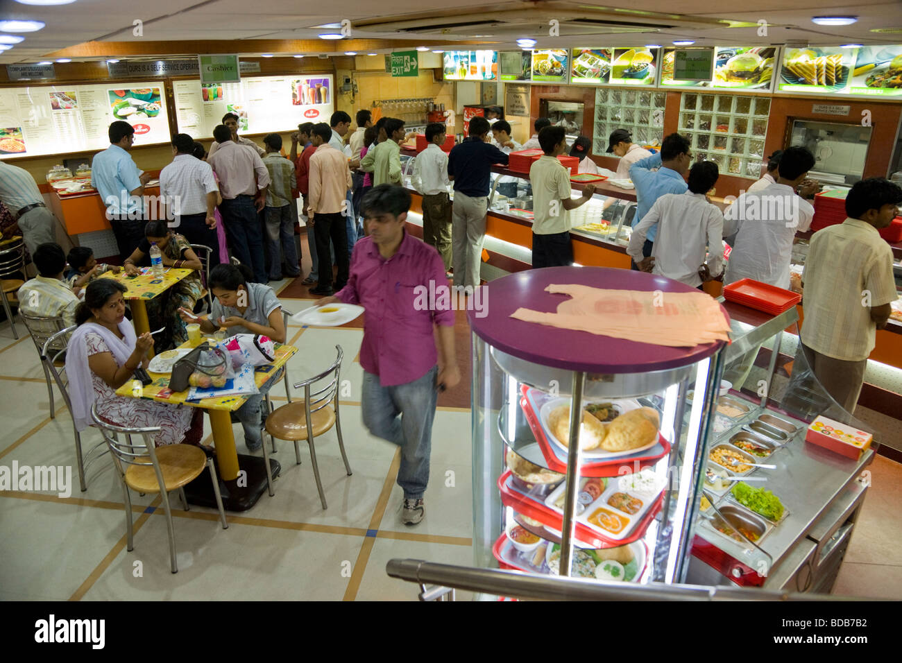 Indian customers queue for fast food for sale at the counter in ...
