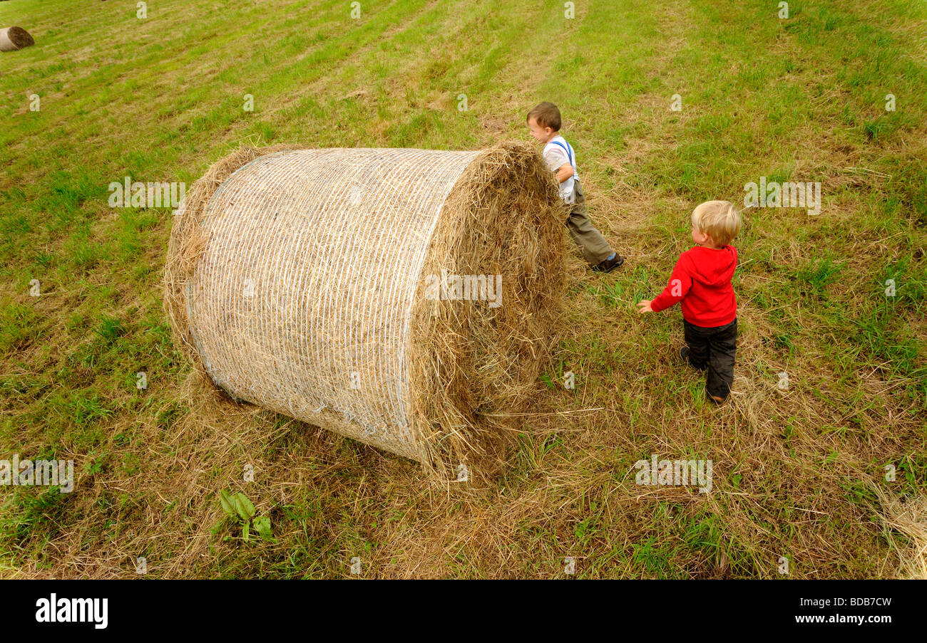 2 3 years old children boys playing on field with hay bale Stock Photo ...