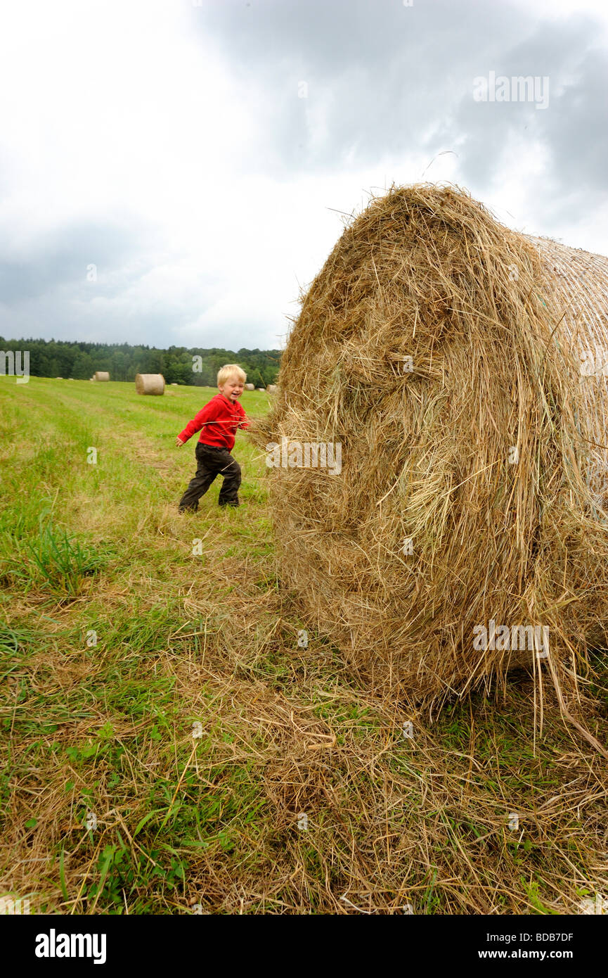 2 3 years old child blond boy playing on field with hay bale Stock ...
