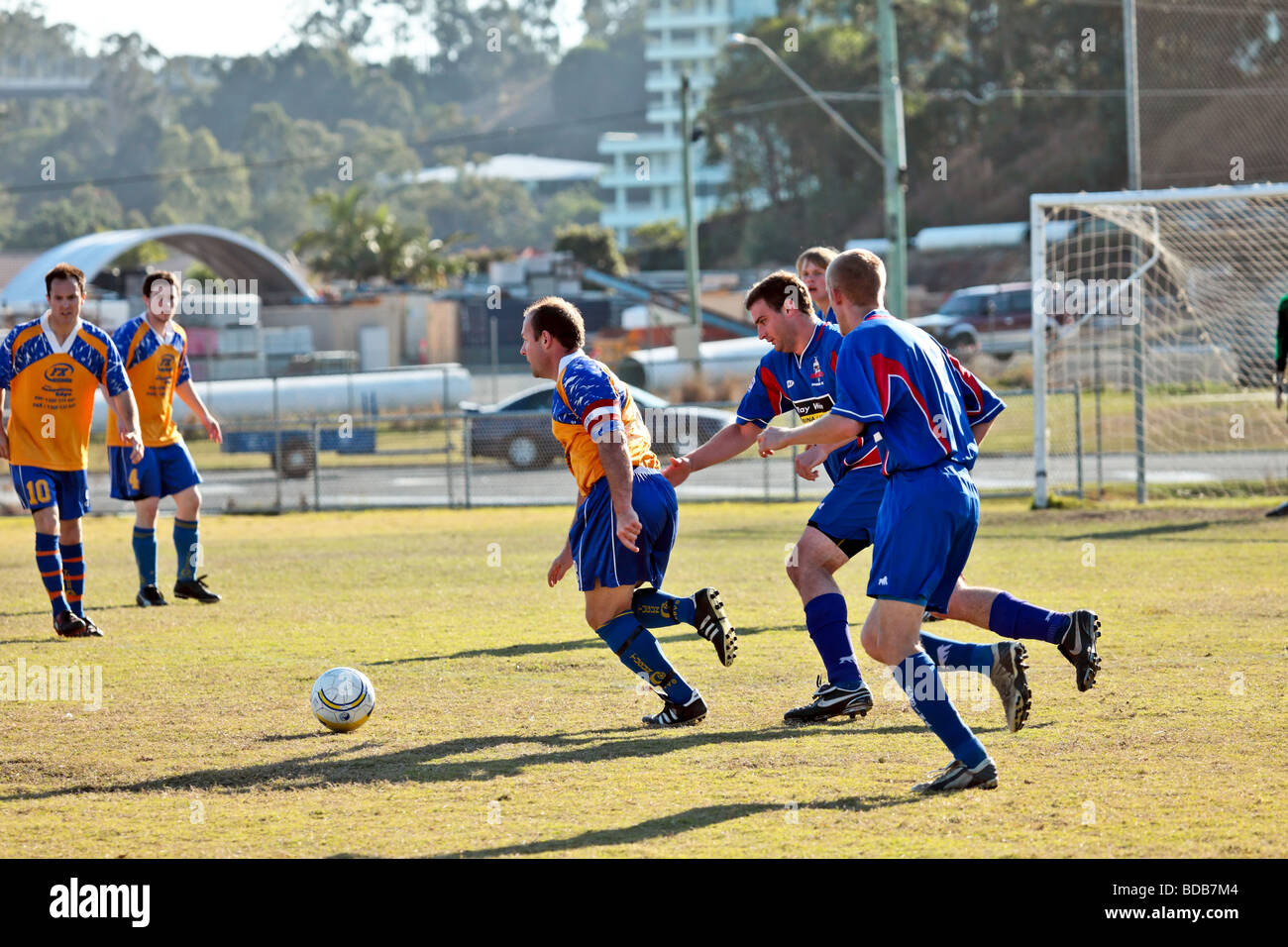 Two soccer teams playing a match heading the ball dribbling and kicking ...