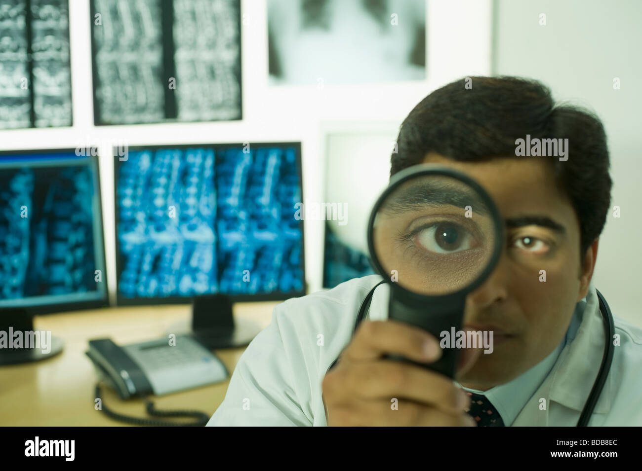 Male doctor holding a magnifying glass Stock Photo - Alamy